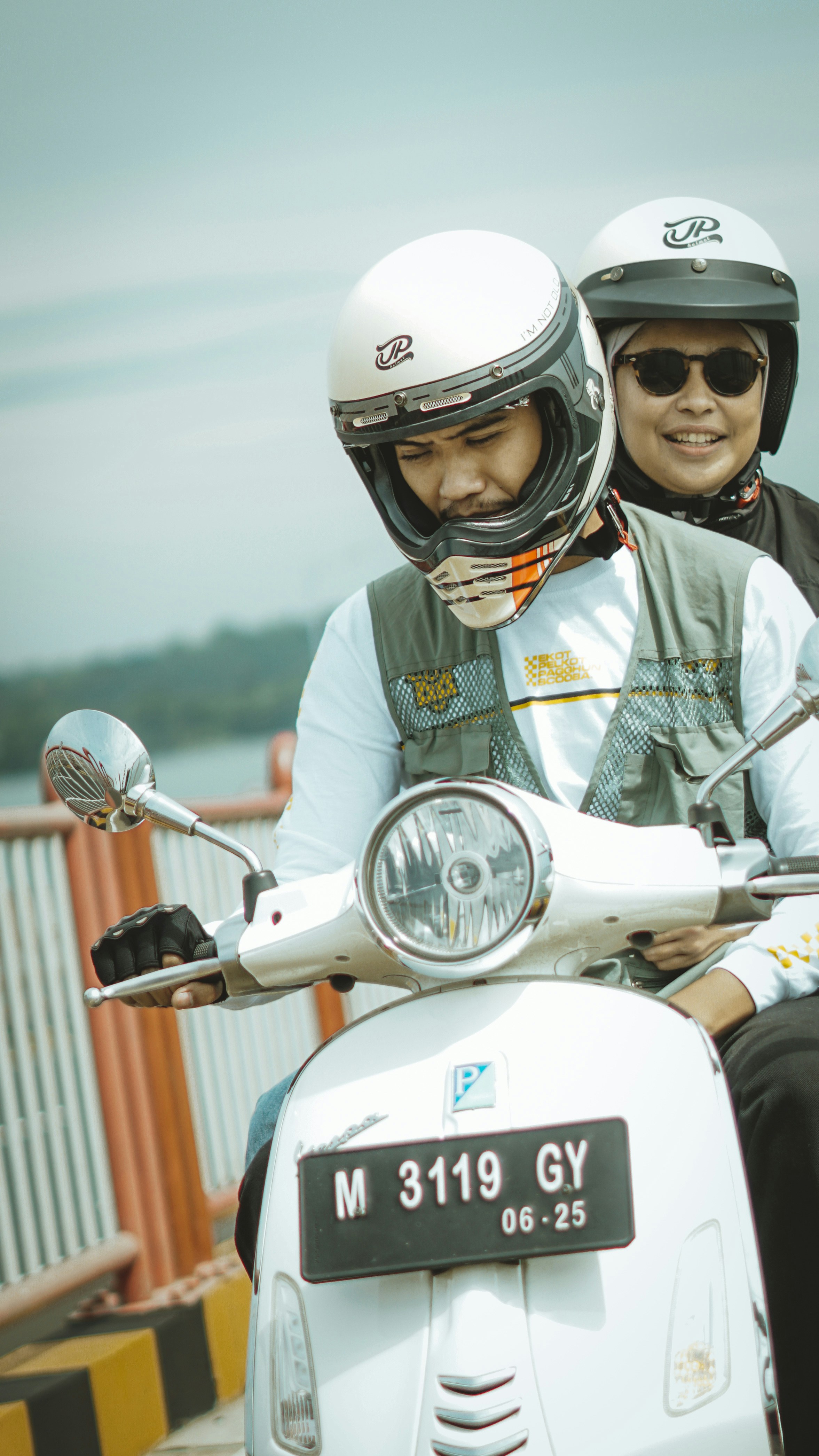 Riverfront Duo: White Vespa Pause Under the Bridge