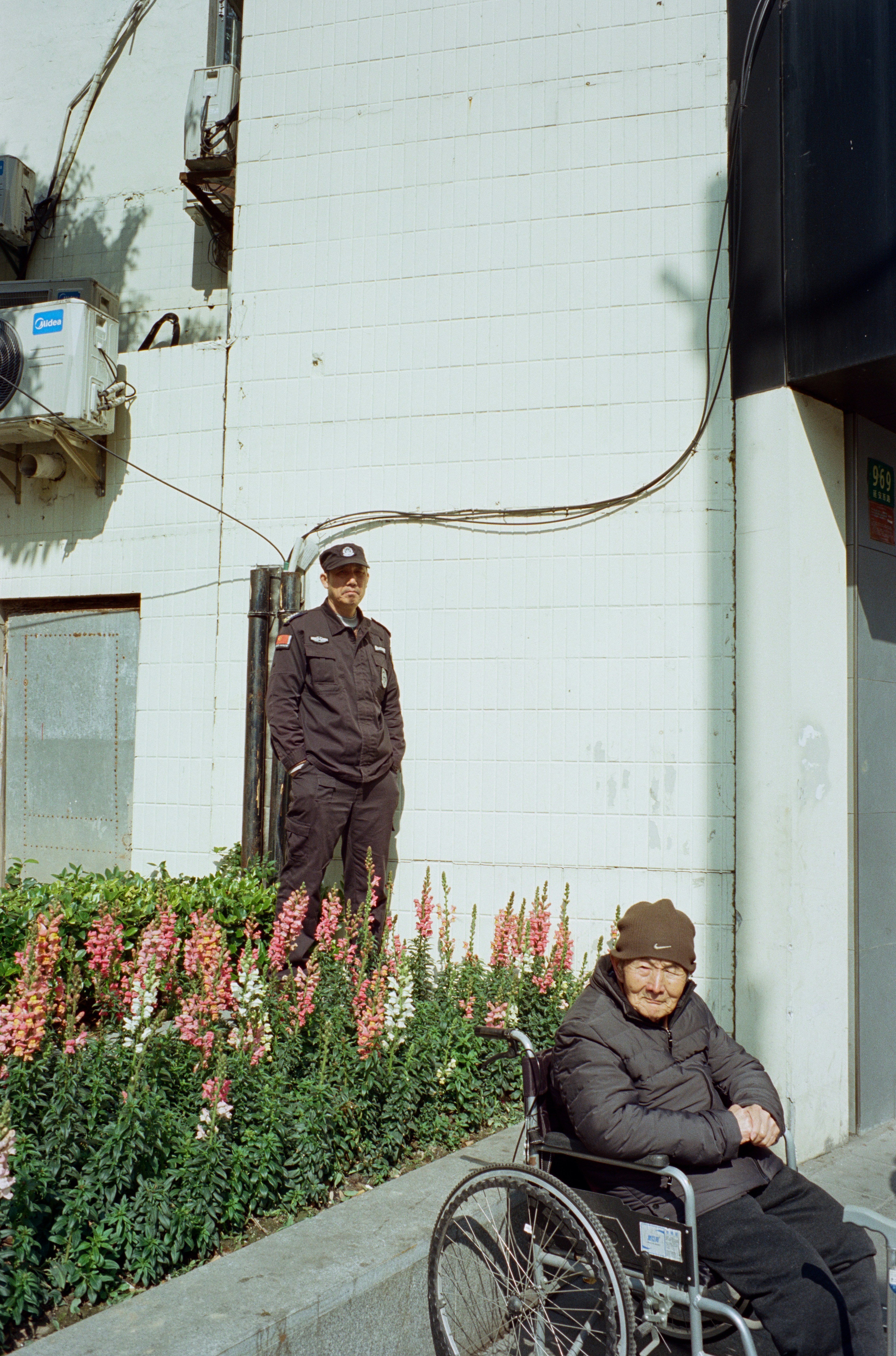 A security guard stands while person sits in a wheelchair. photo – Free ...