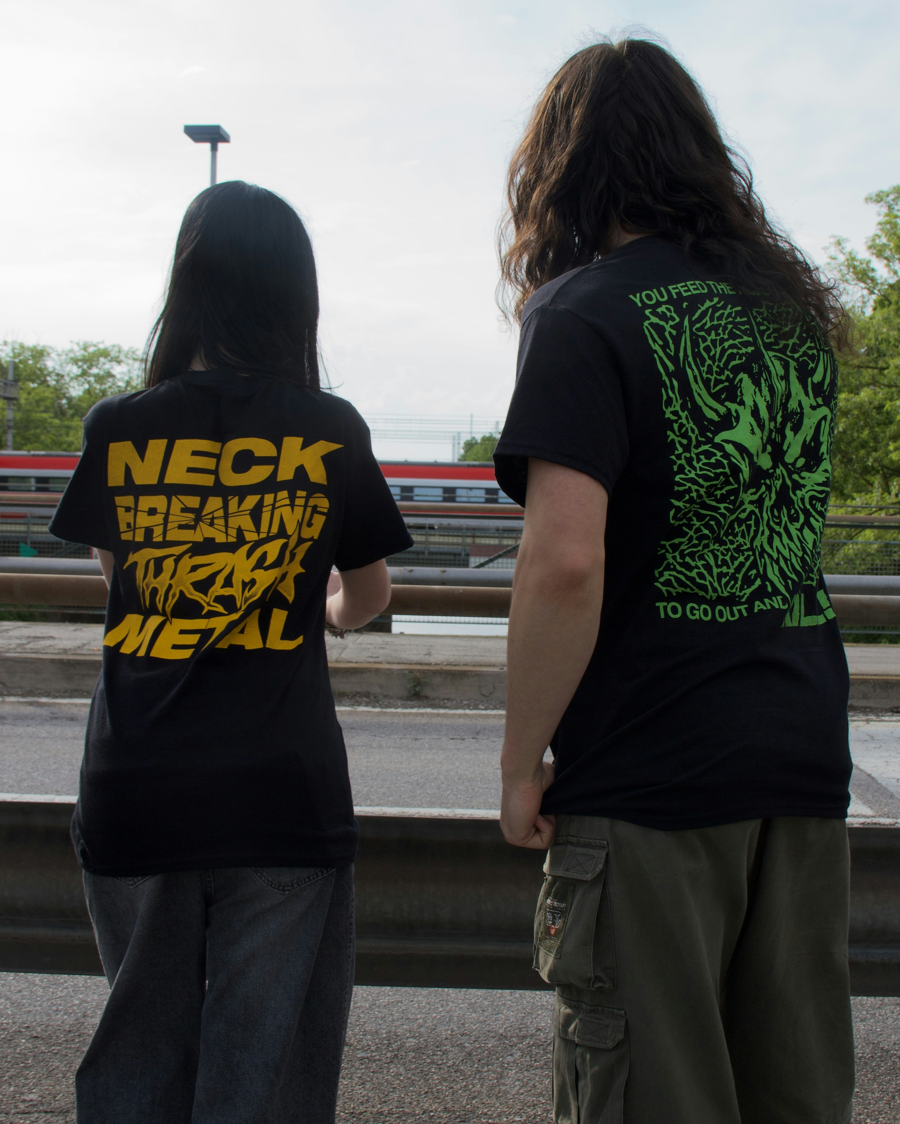 Back-View Duo in Graphic Tees by the Stadium Rail