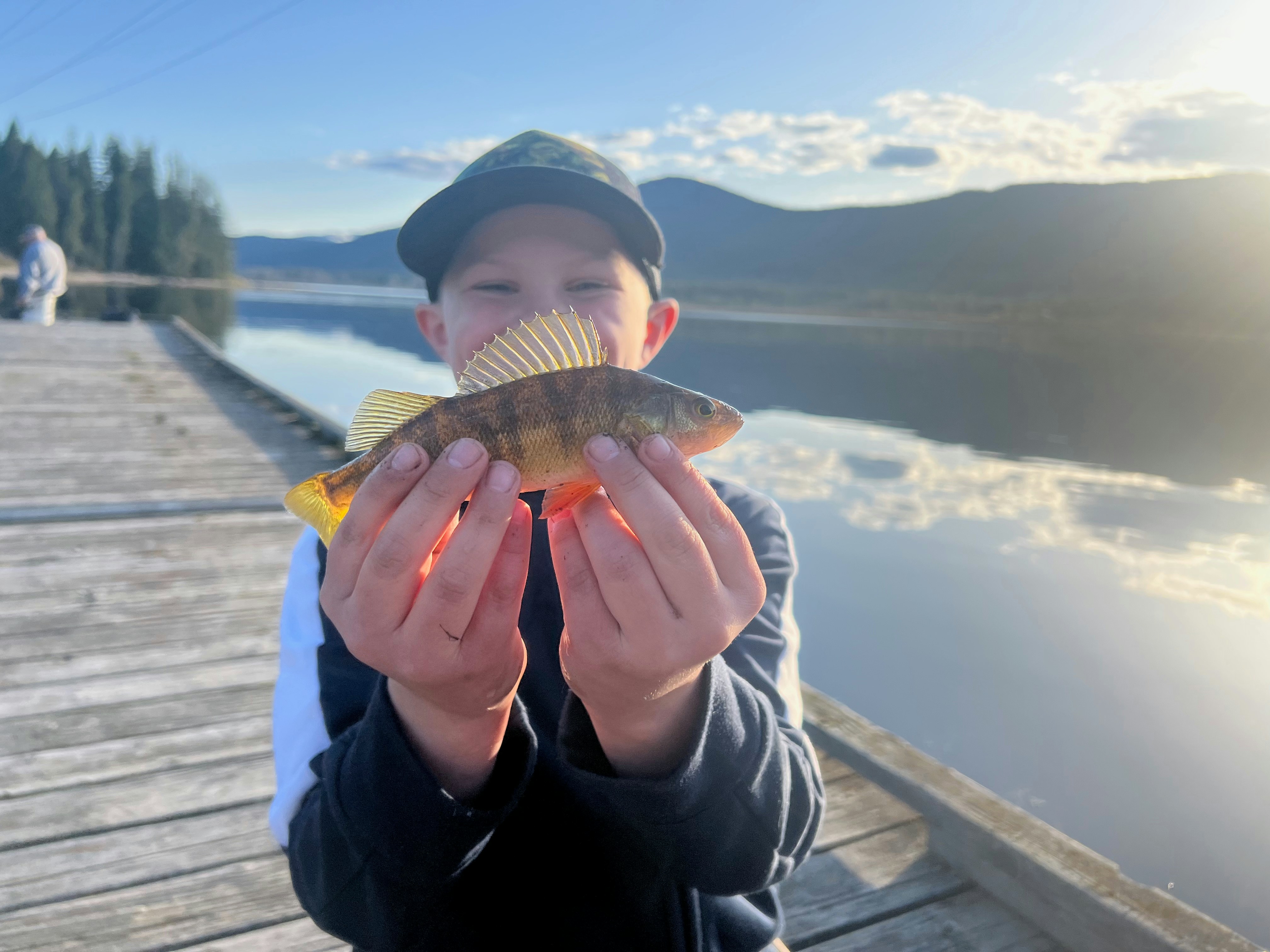 Boy proudly shows off his fresh catch. photo – Free Lake Image on Unsplash