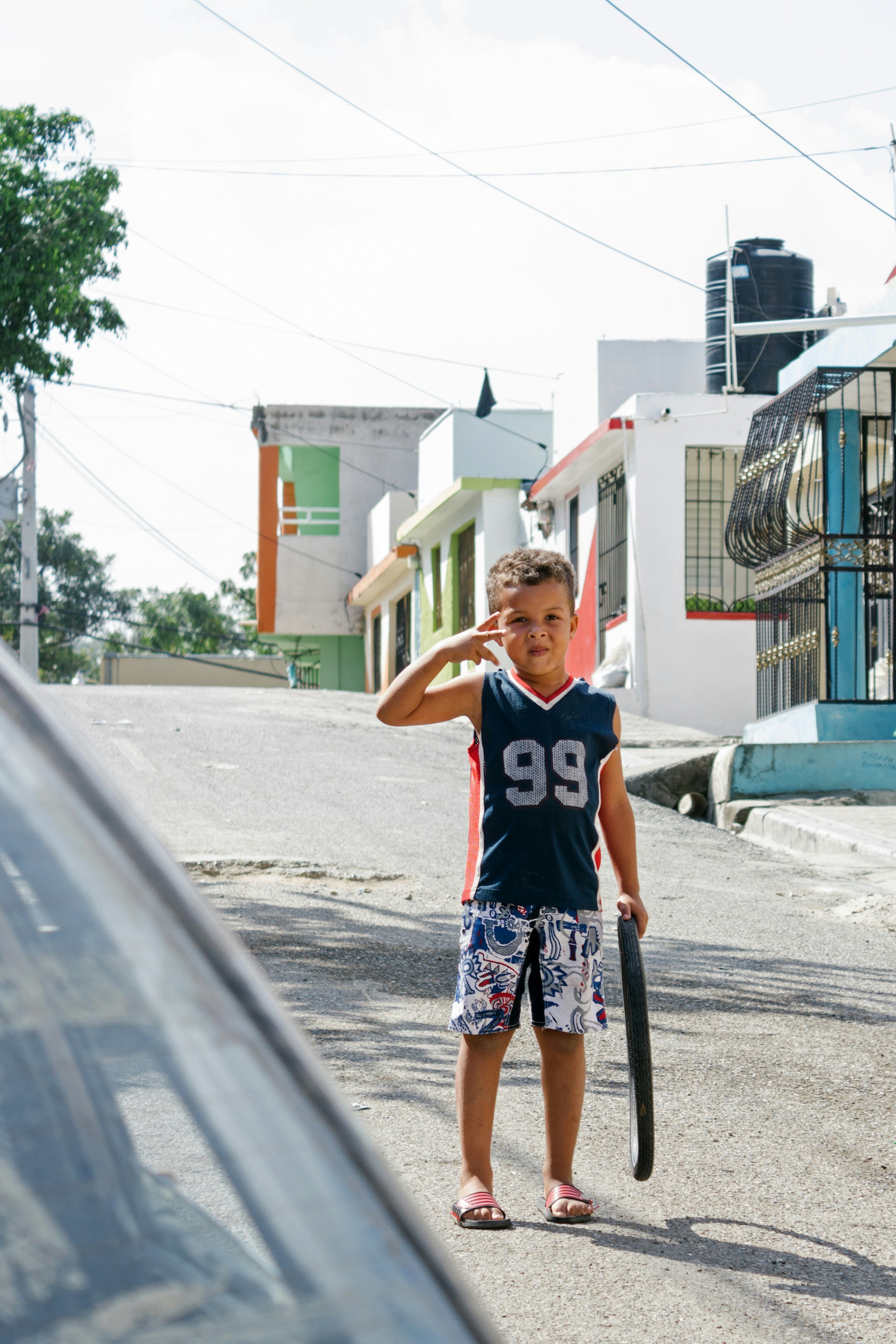 Young street-side defender: a boy with a boomerang stands under sunlit rooftops