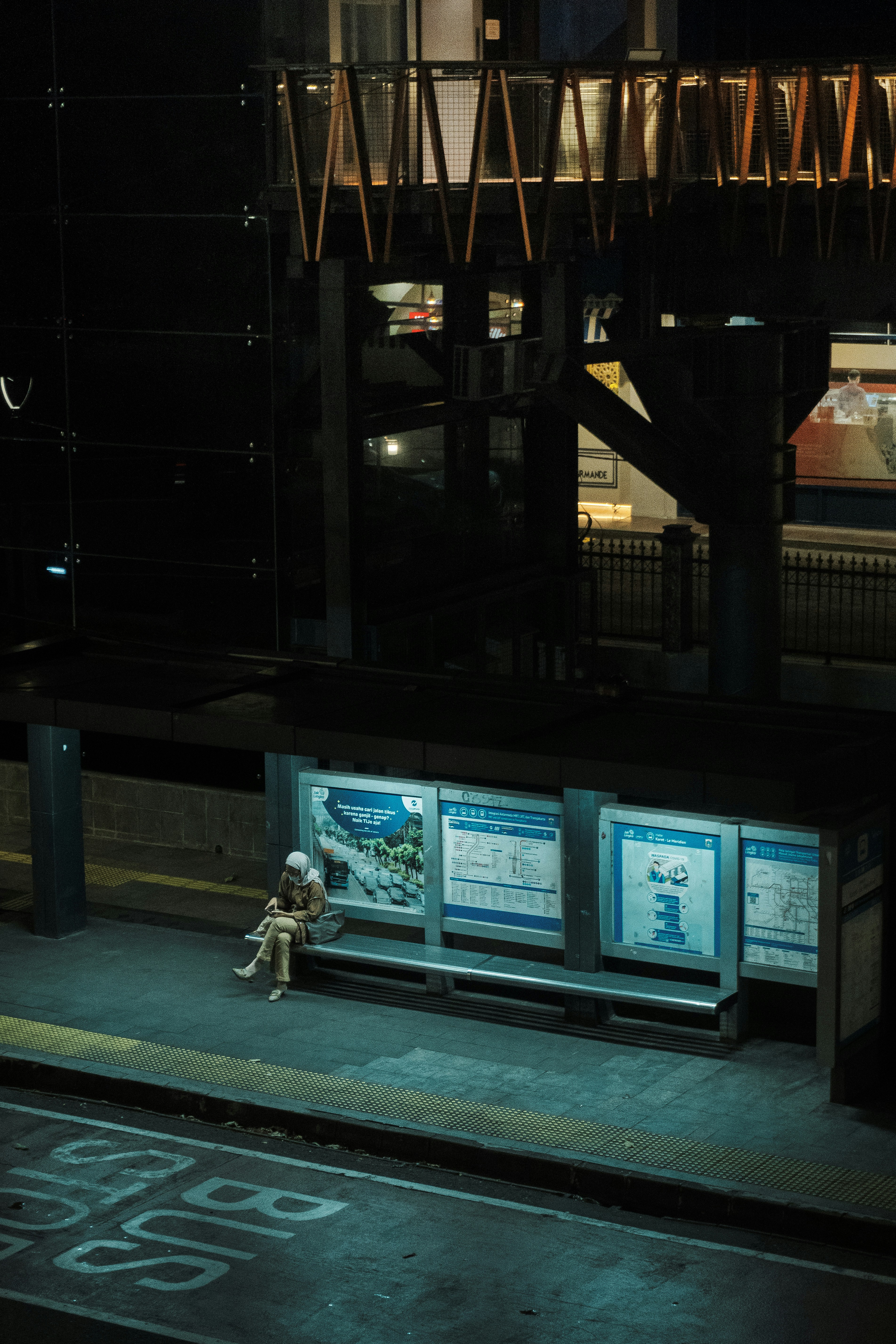 A person sits alone at a bus stop at night. photo – Free Wallpaper ...