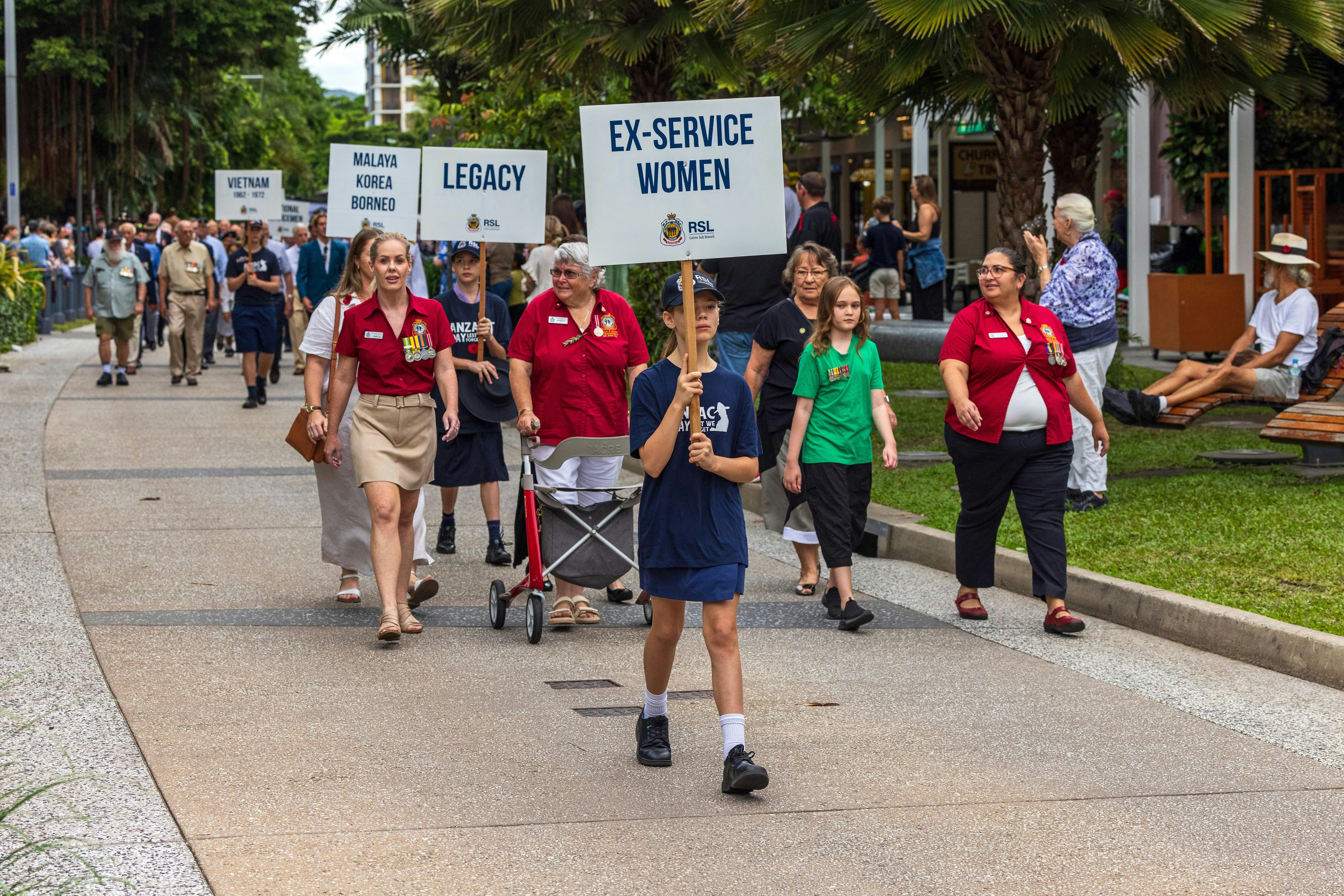 People march with signs in a parade. photo – Free Anzac Image on Unsplash
