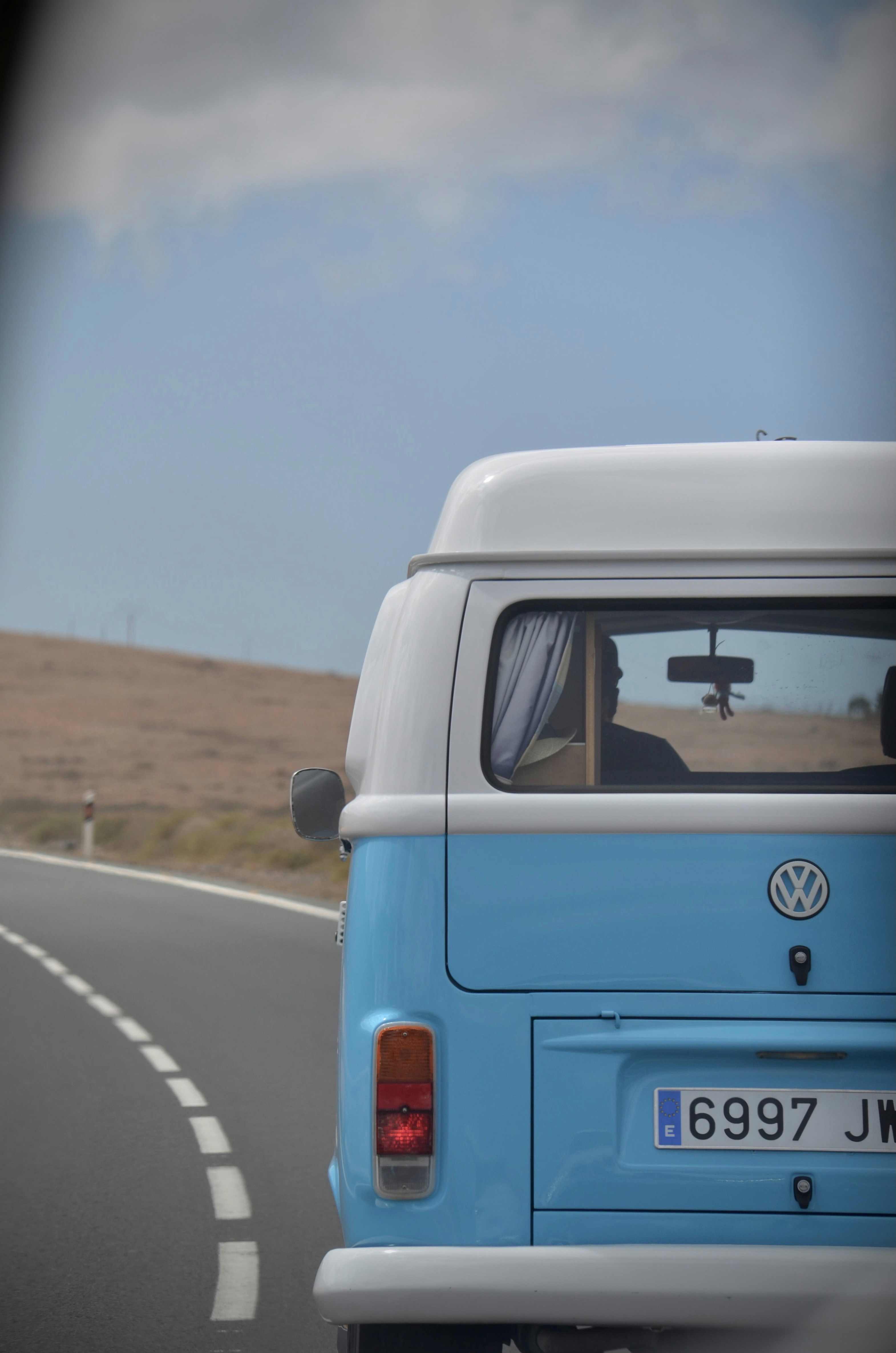 A blue volkswagen bus is driving down the road. photo – Free ...