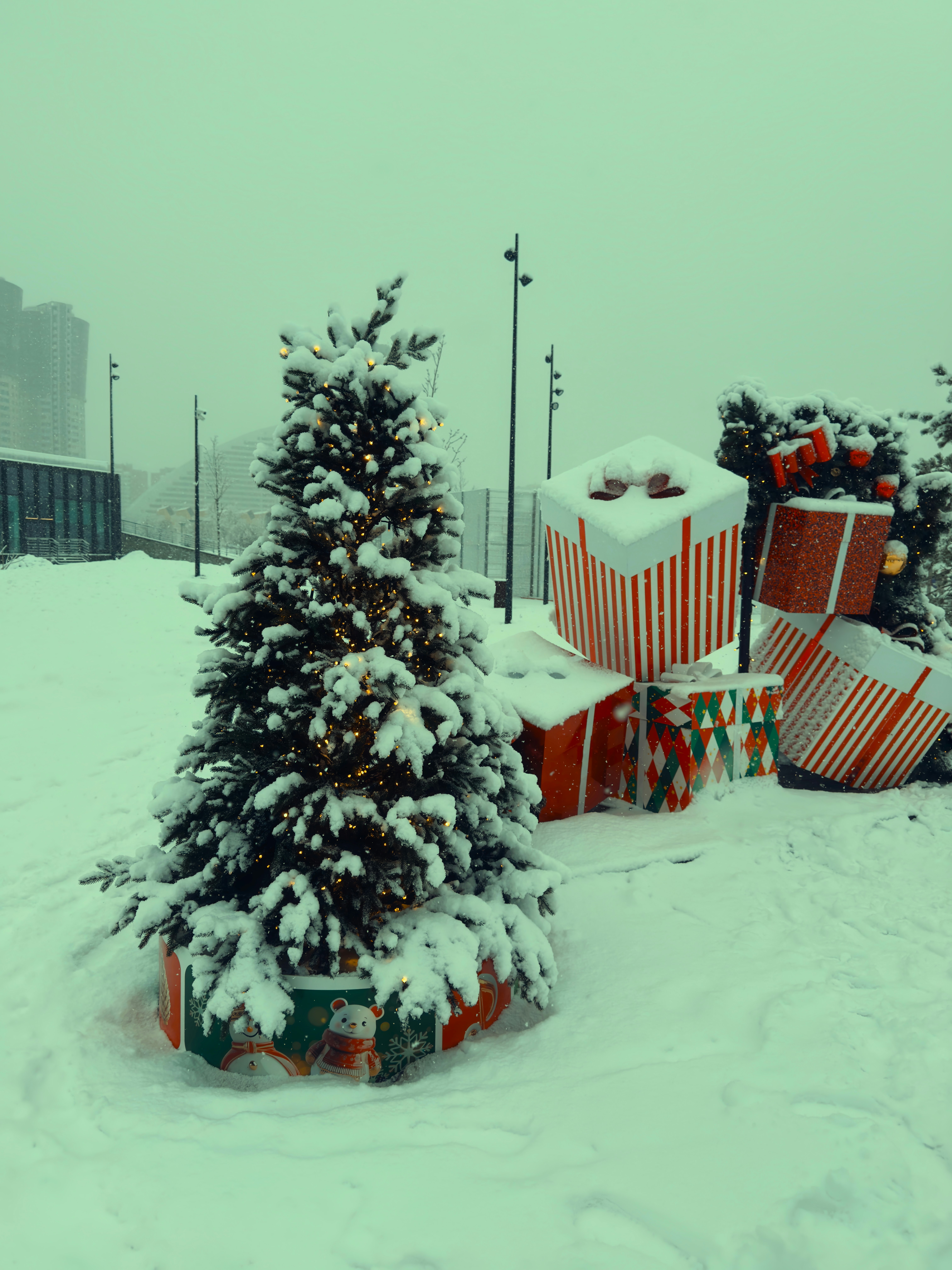 Christmas tree and gifts covered in snow.