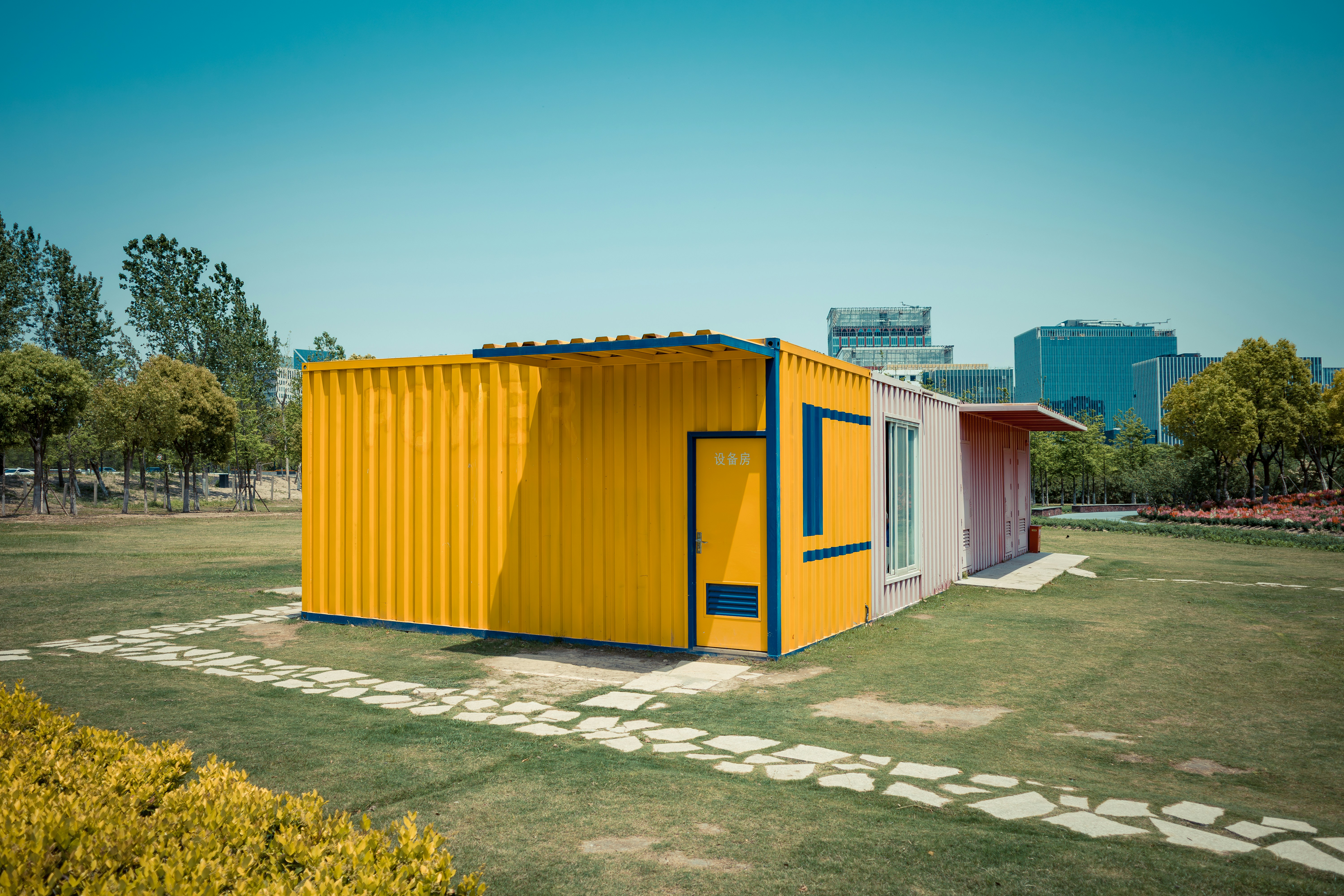 A bright yellow shipping container home on a green lawn. photo – Free ...