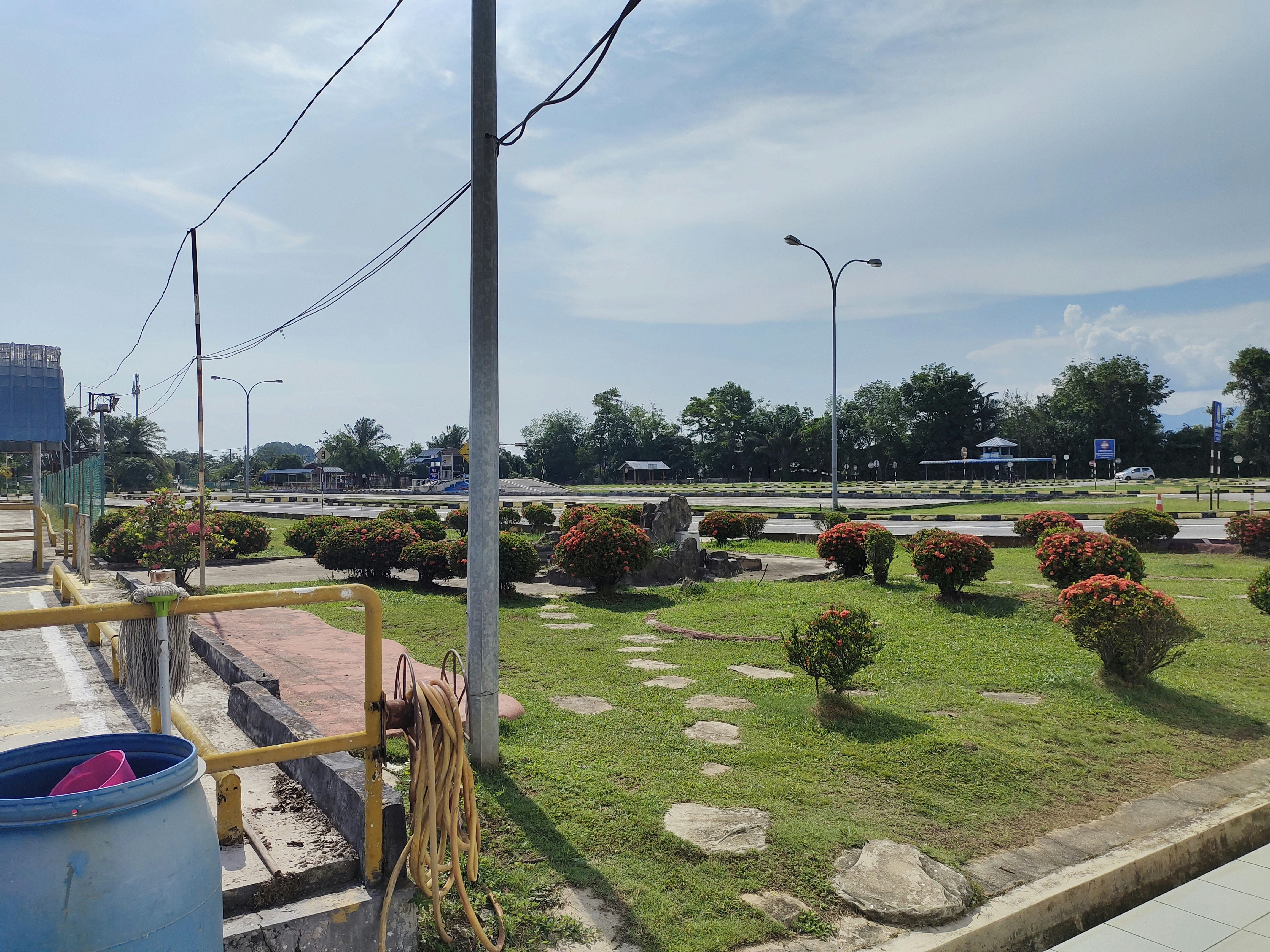 A roadside view with greenery and streetlights. photo – Free Road Image ...