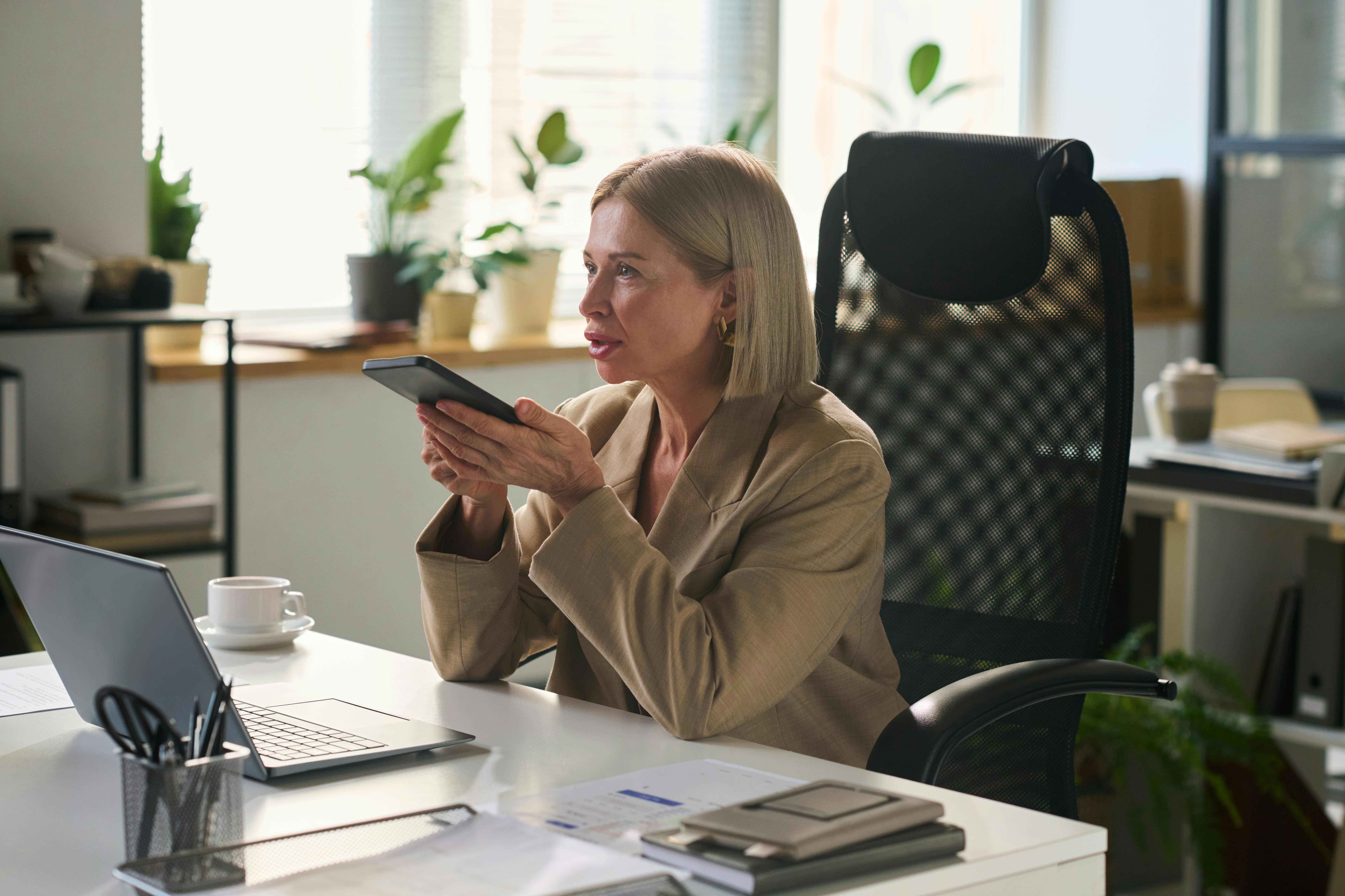 Woman uses a tablet at her office desk. photo – Free Office Image on ...