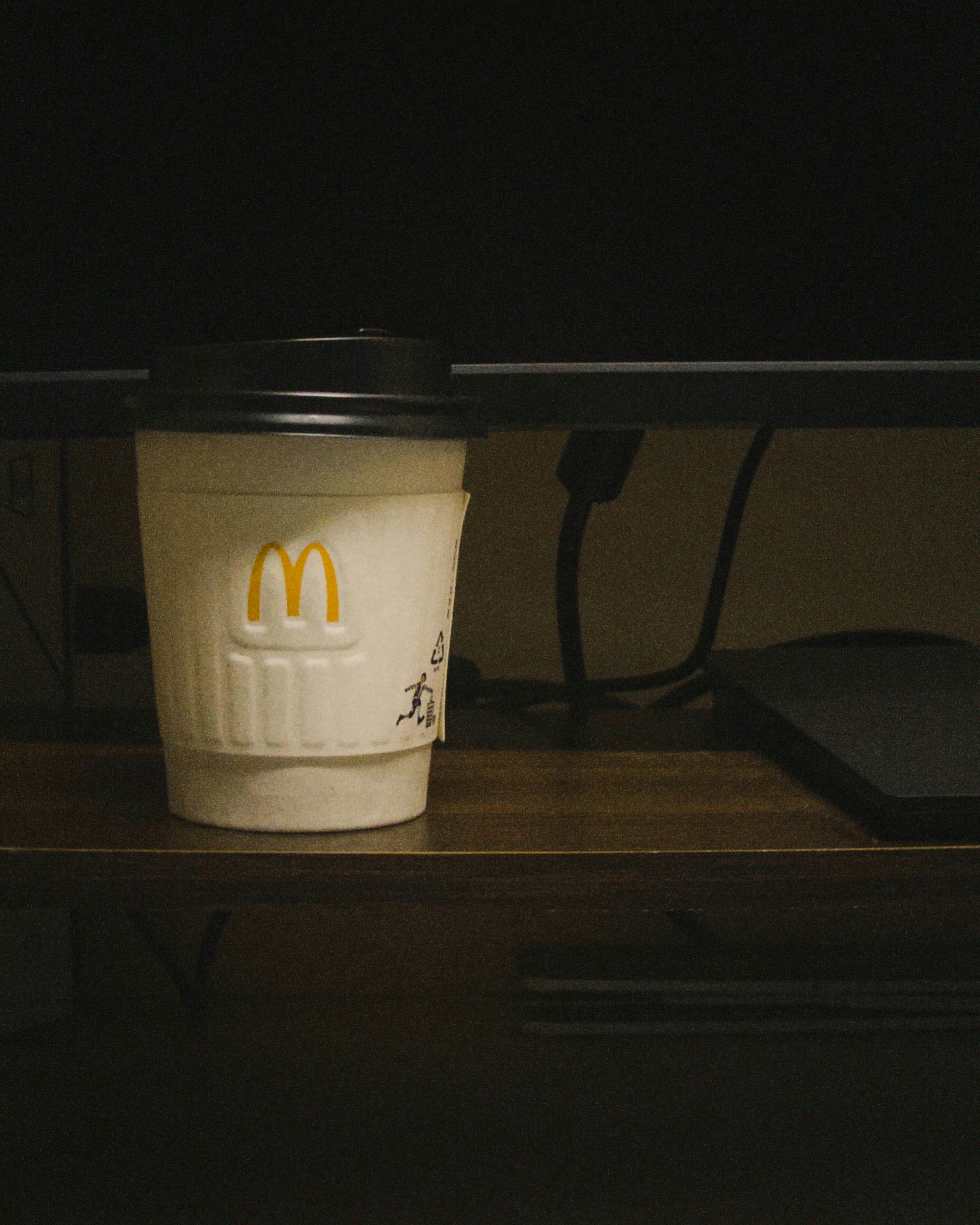 Mcdonald's coffee cup sits on a dark table. photo – Free Image on Unsplash