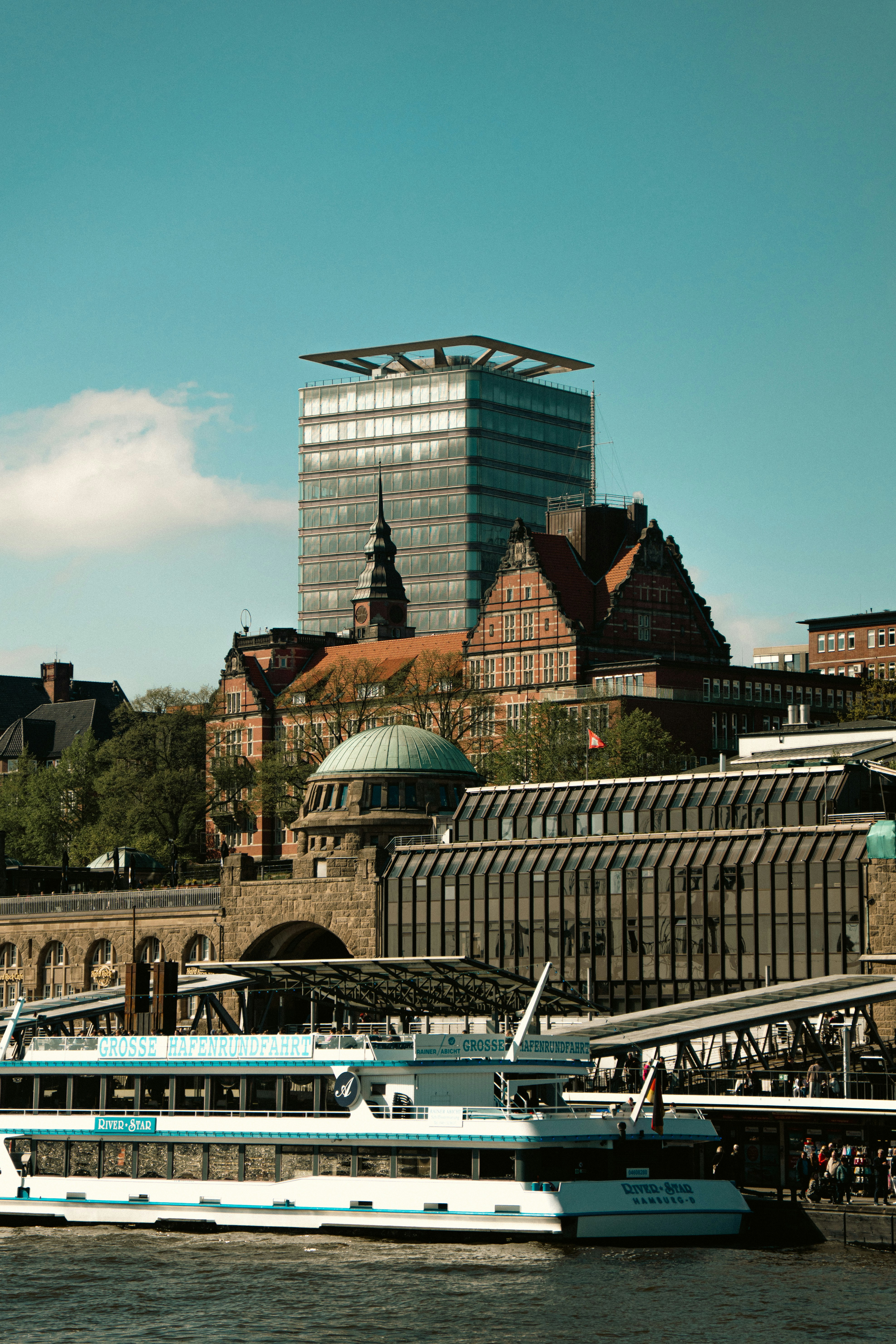 Cityscape features buildings, boat, and clear blue sky.