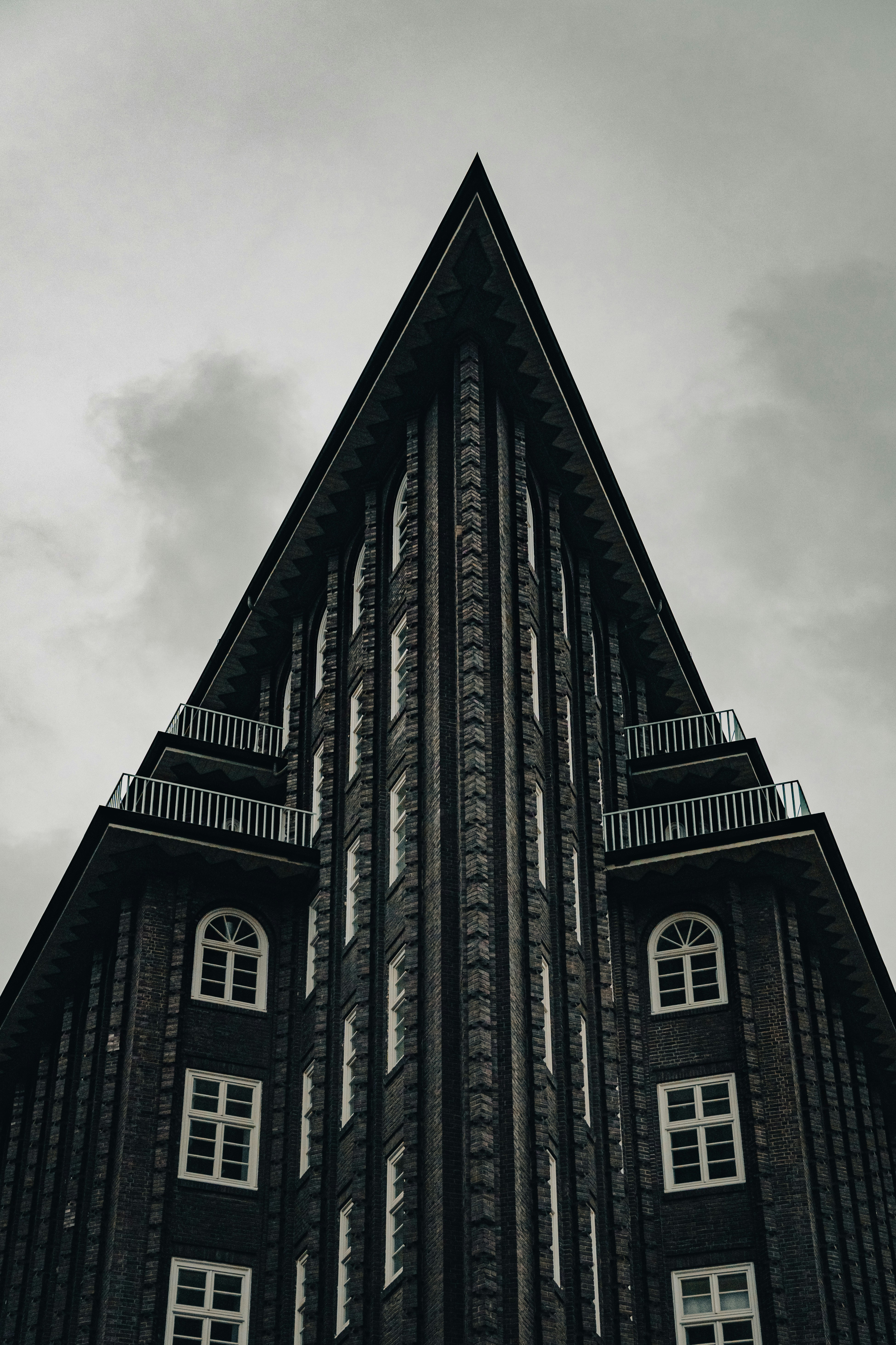 Pointed Summit: A Brick Facade Ascends Toward a Moody Sky