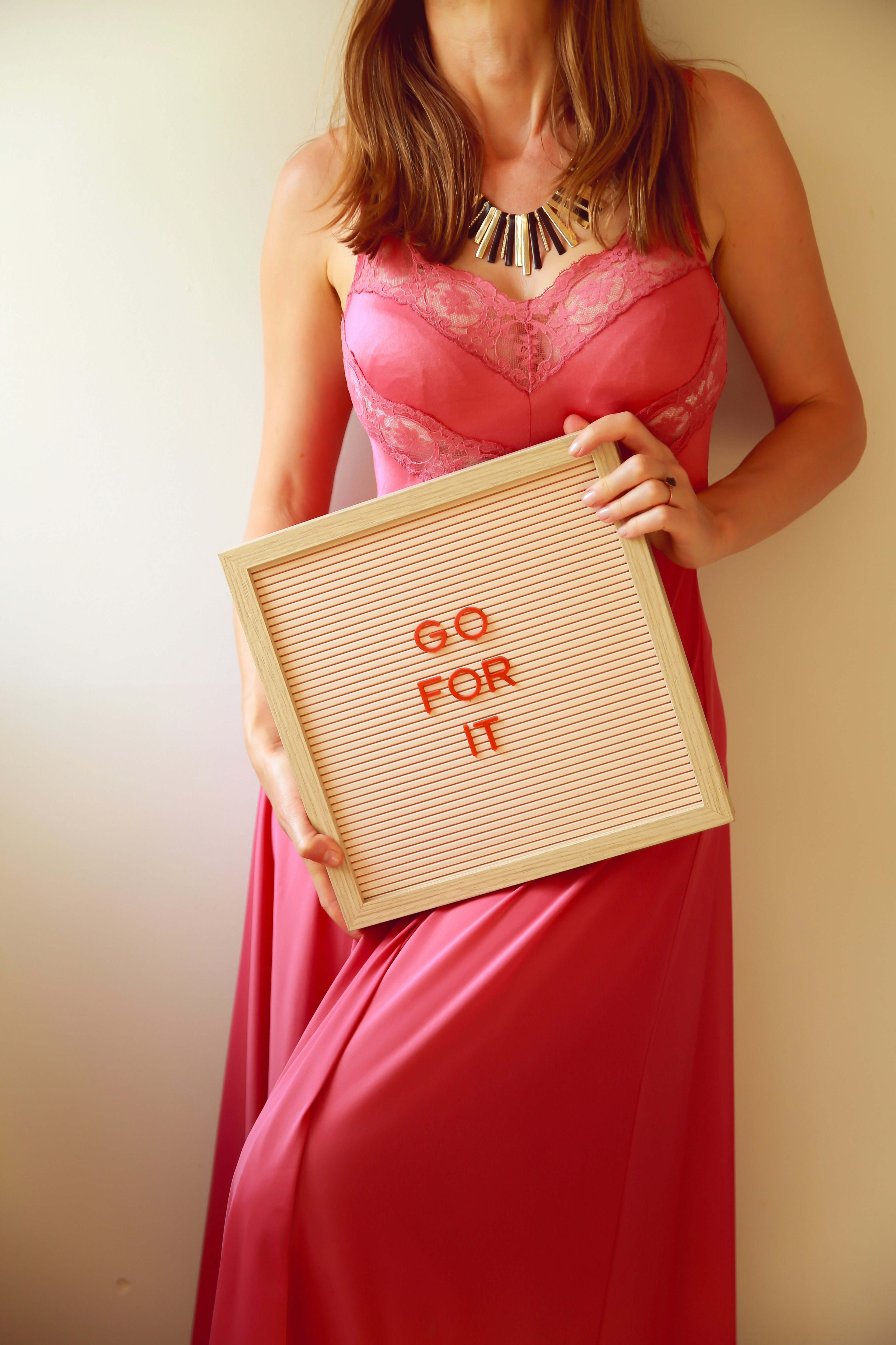 Woman in pink dress holds a "go for it" sign. photo – Free Woman Image ...