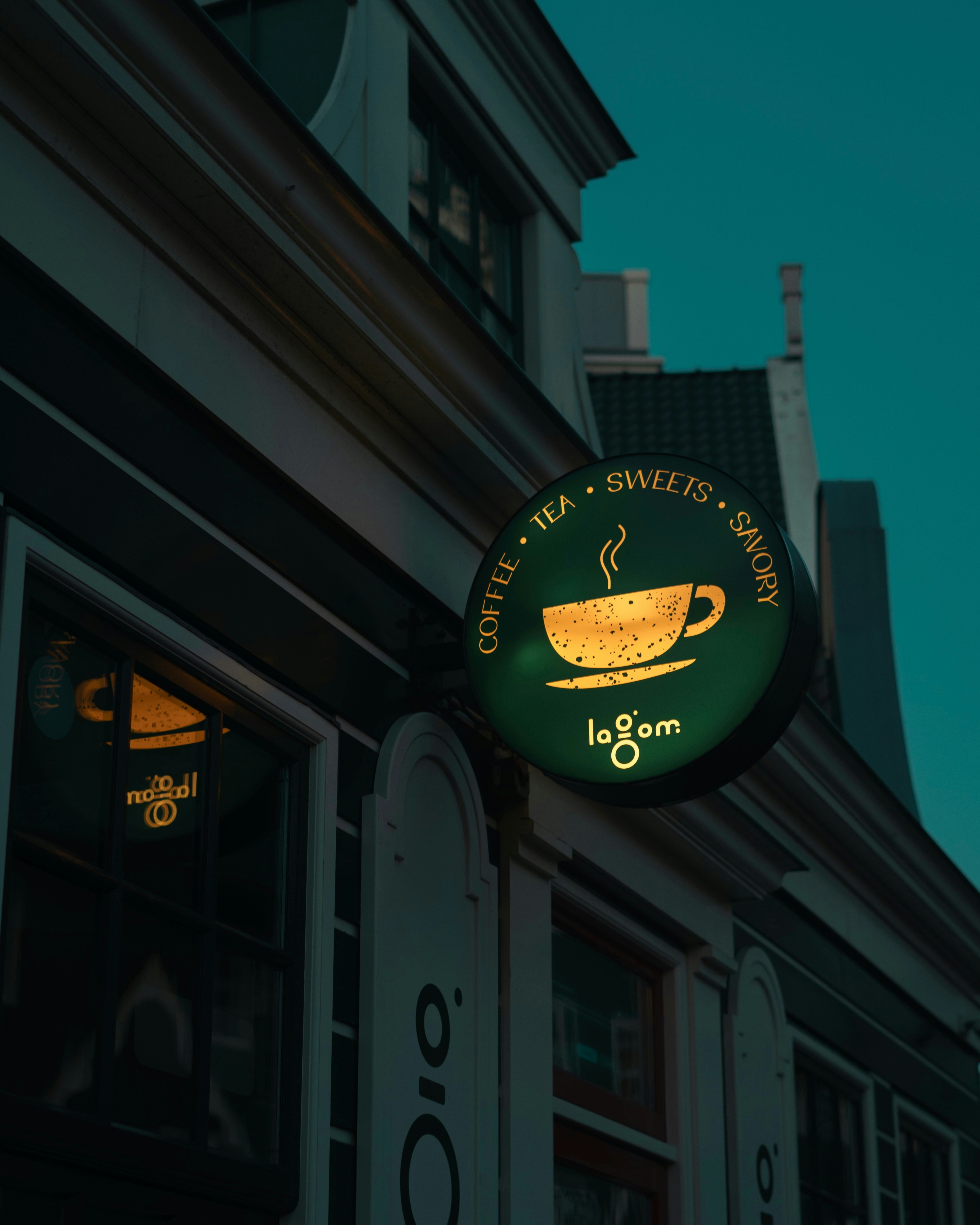 A coffee shop sign illuminates against a teal sky. photo – Free Image ...
