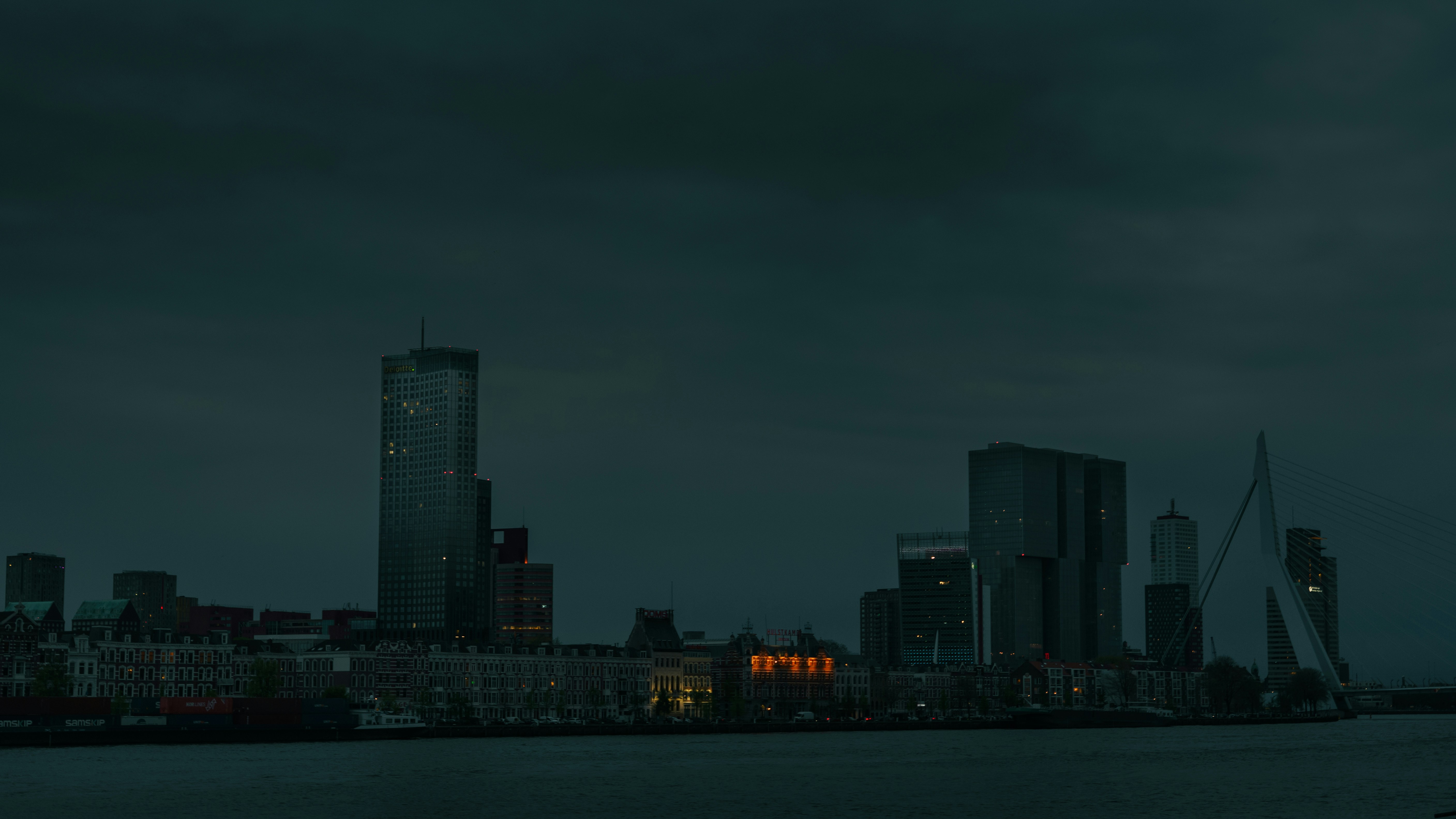 City skyline at dusk under a dark sky.