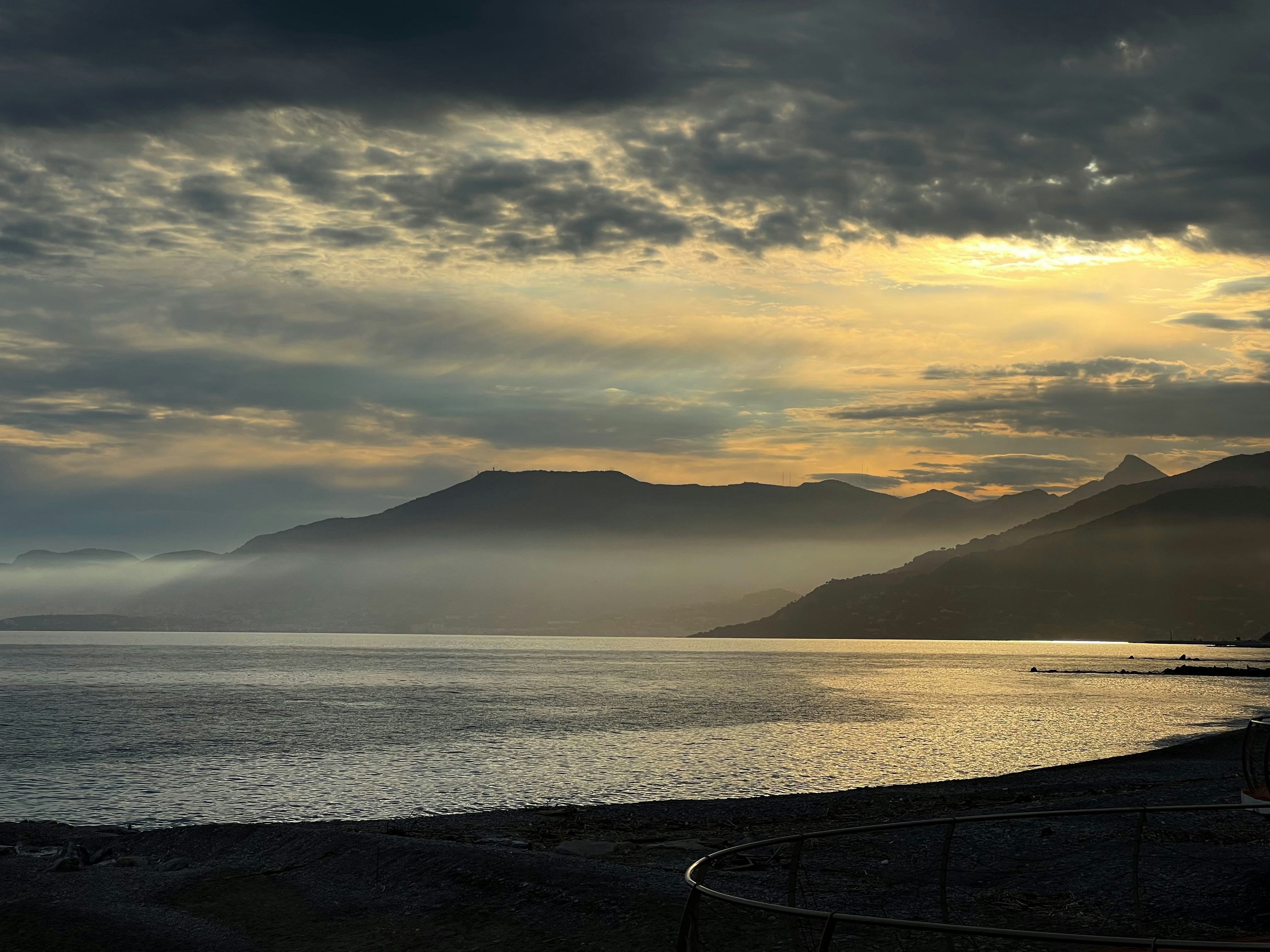 Sunrise over a misty lake and mountains.