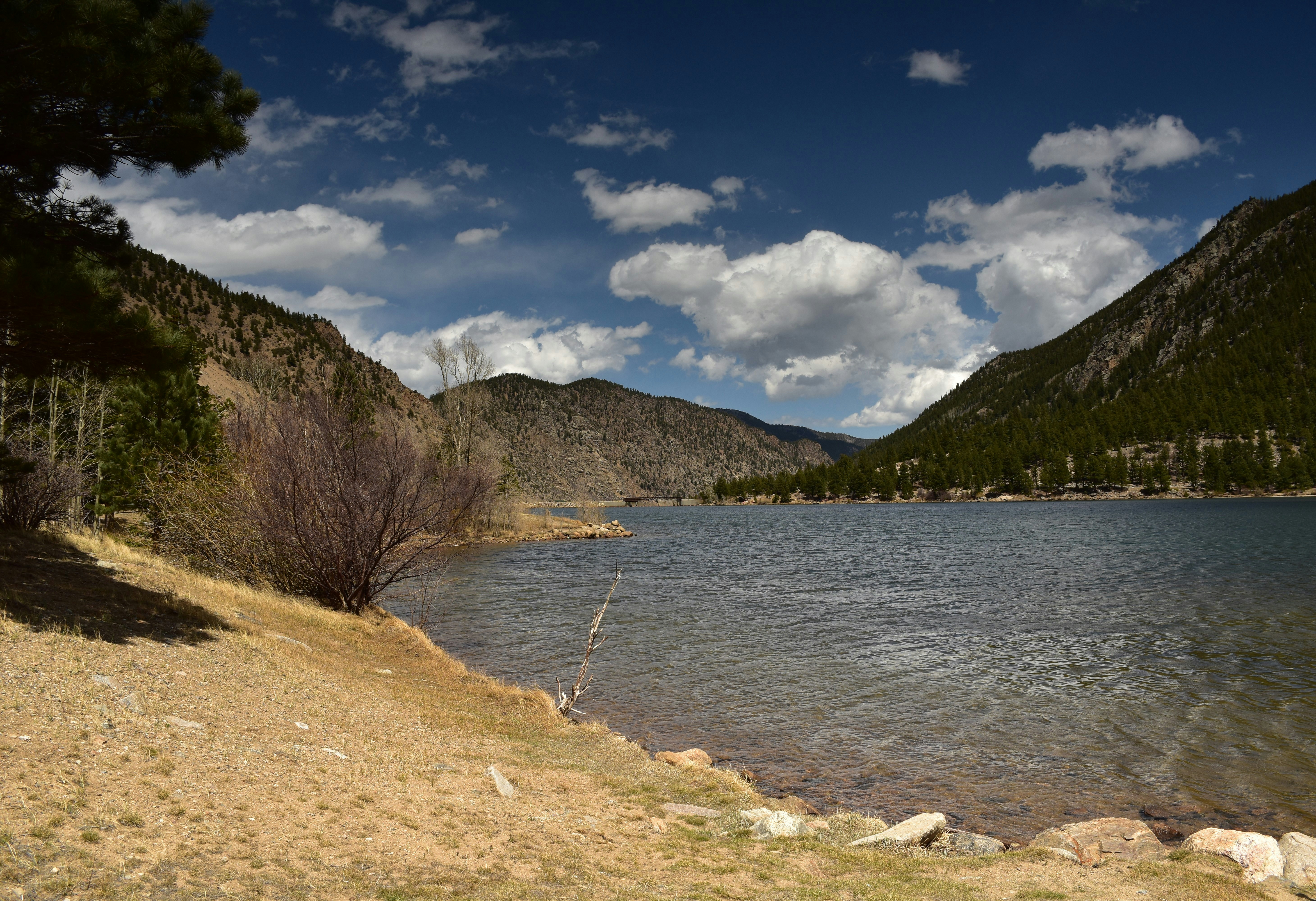 A lake sits between two mountains. photo – Free Image on Unsplash