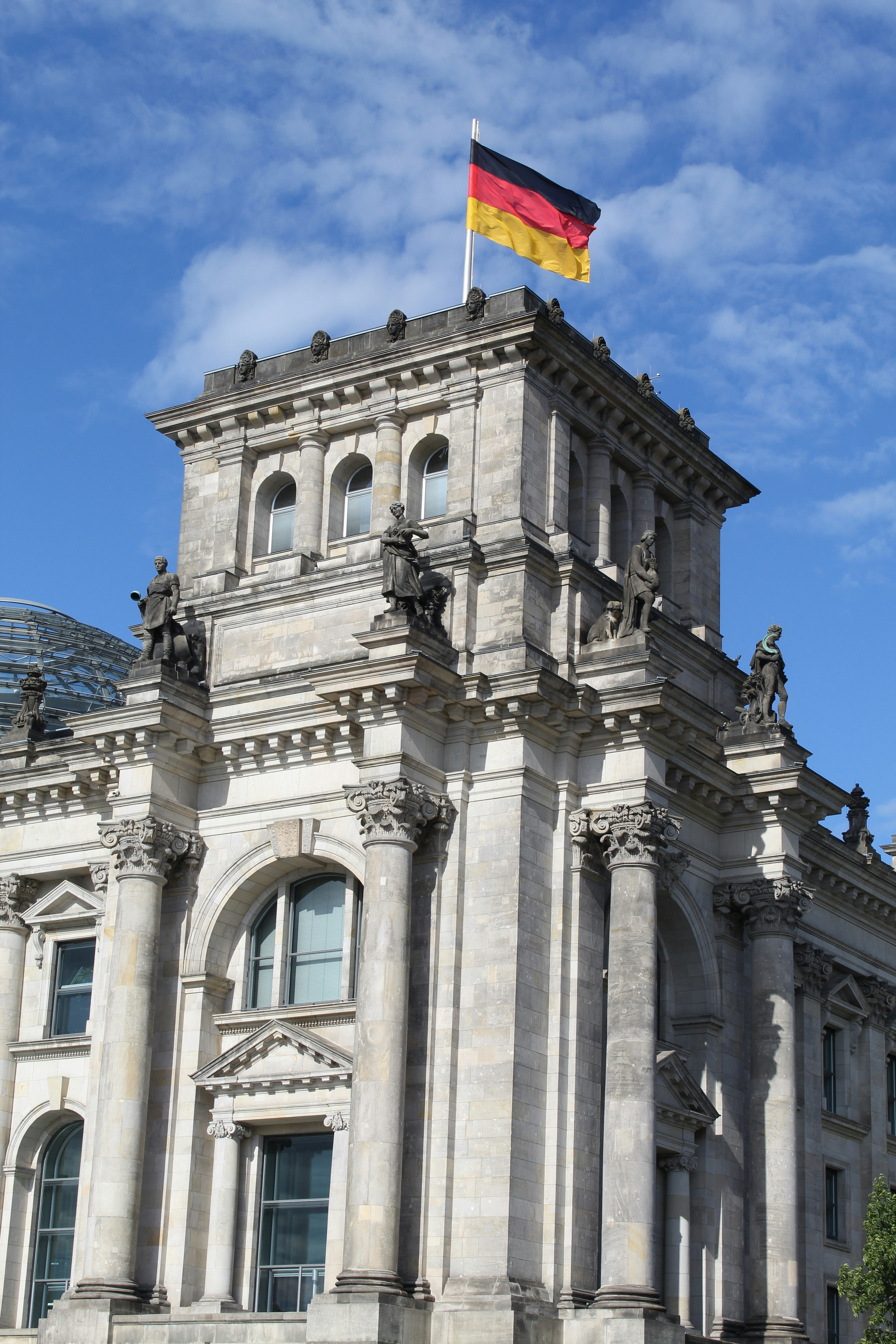 Flag Over a Grand Stone Facade: Sculptural Architecture Under a Bright Sky