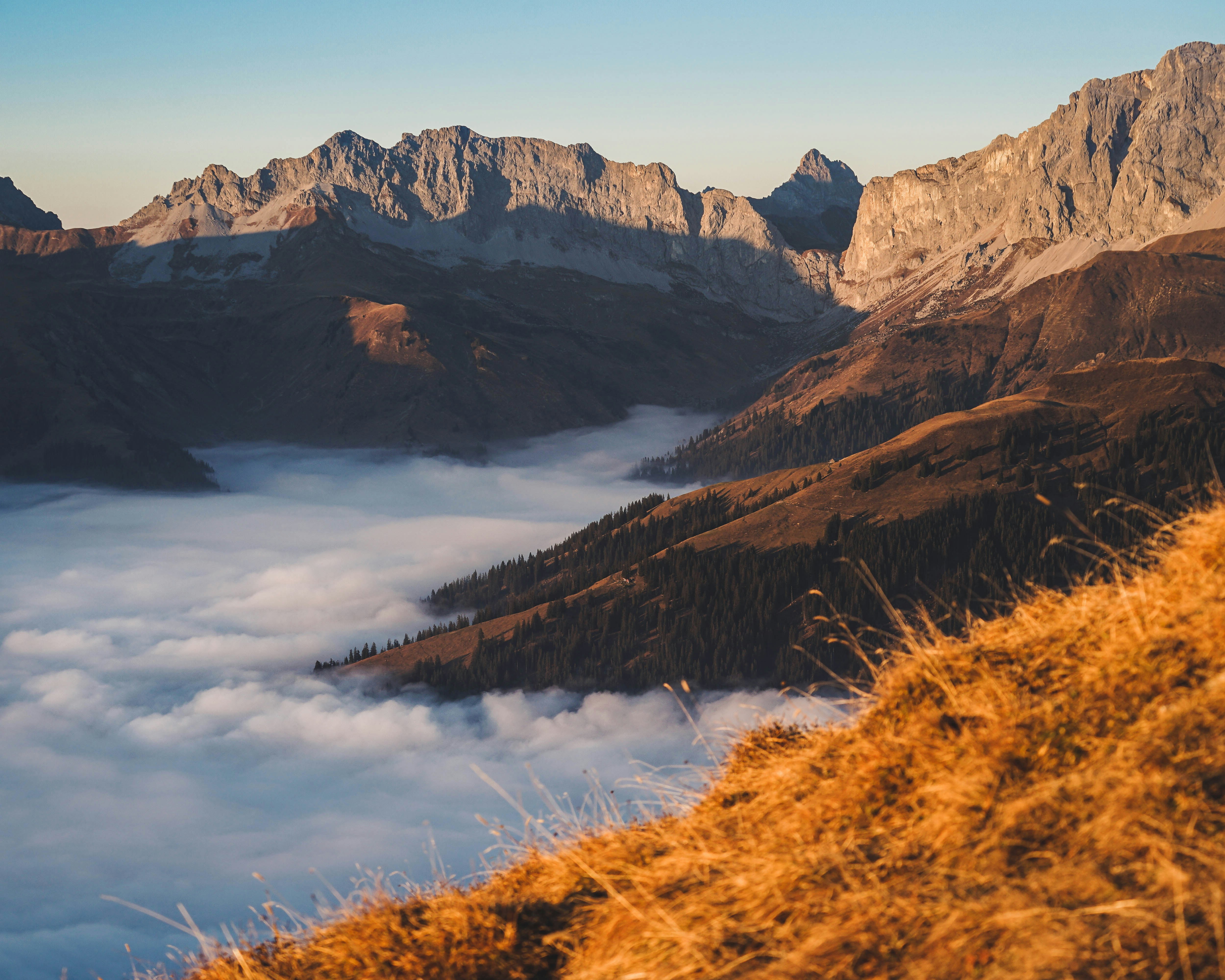 Mountains rise above the clouds at sunrise. photo – Free Golden hour ...
