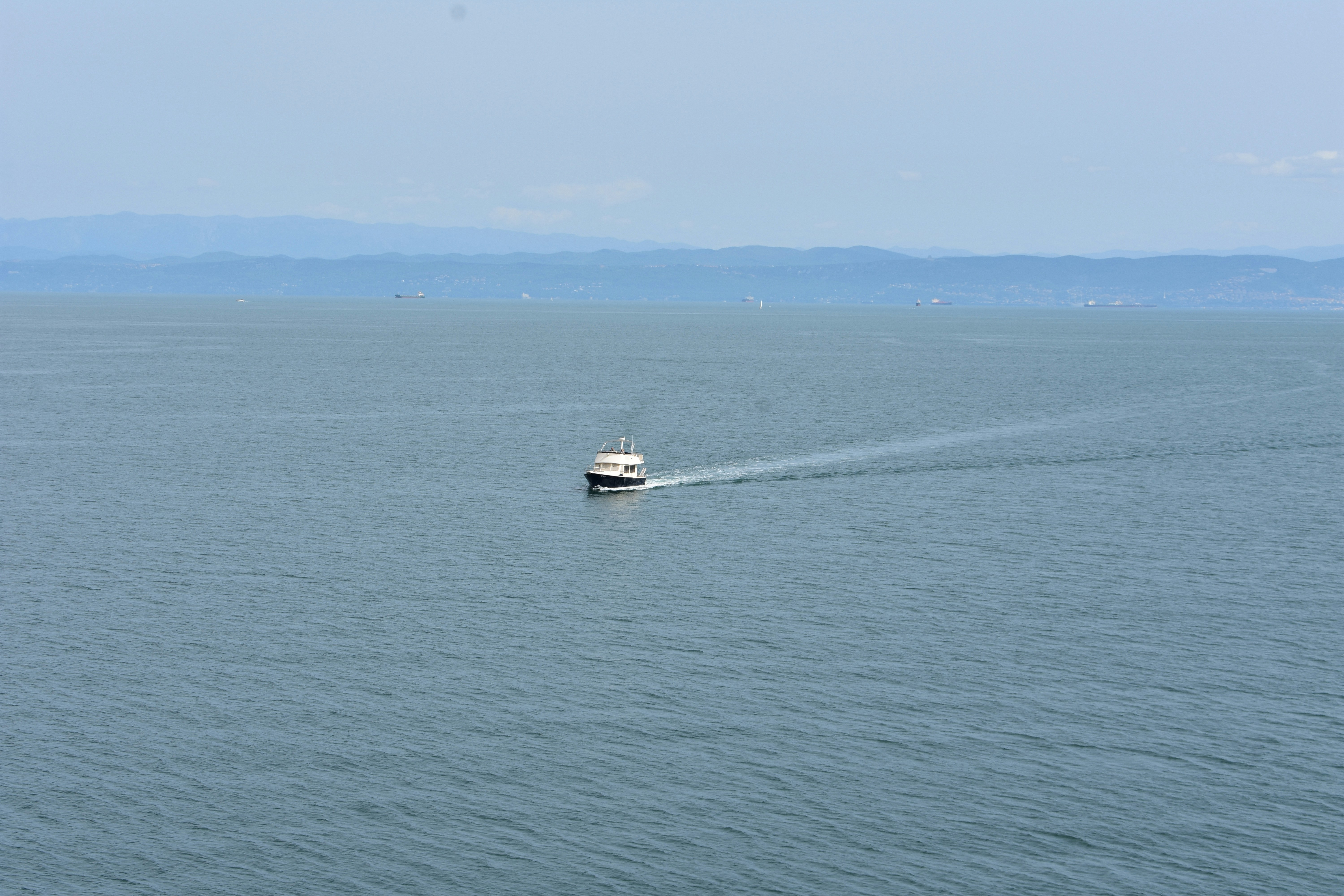 A boat travels across the open, blue water. photo – Free Image on Unsplash