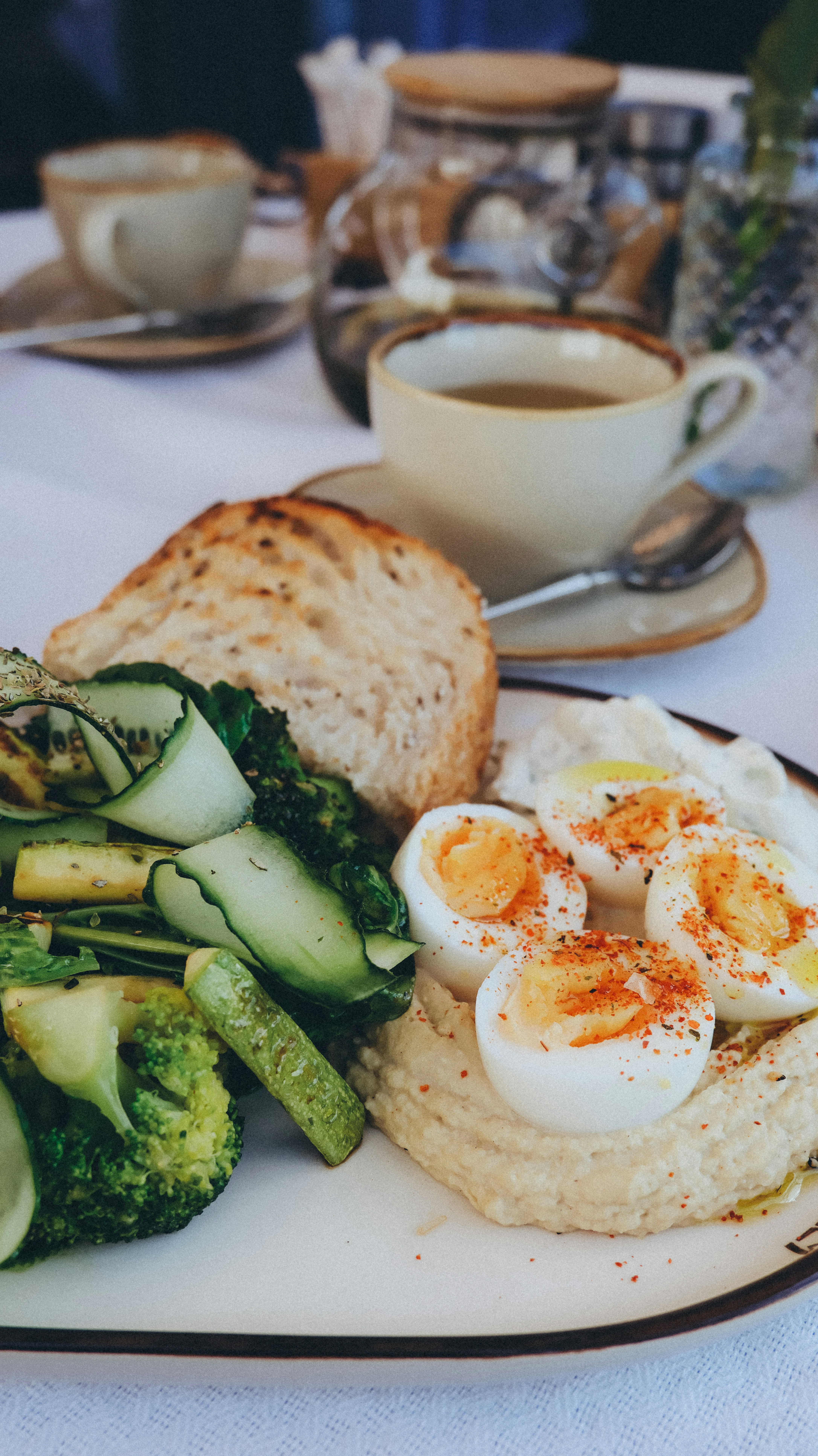 Sunlit Plate: Soft-Boiled Eggs, Greens, and Hummus on a Breakfast Spread