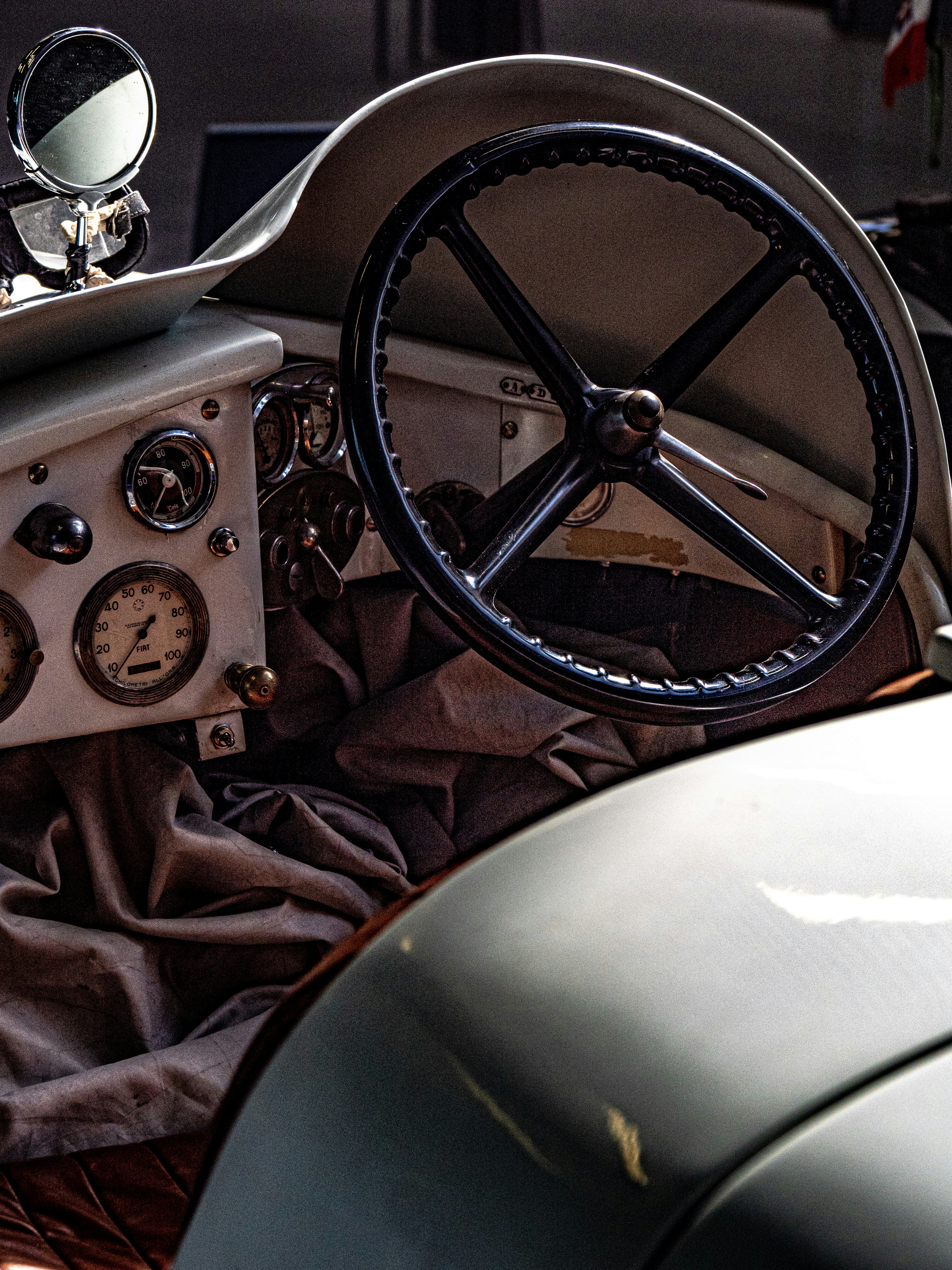 Vintage car dashboard showcasing intricate gauges and a stylish steering wheel. The soft fabric interior adds a touch of luxury.