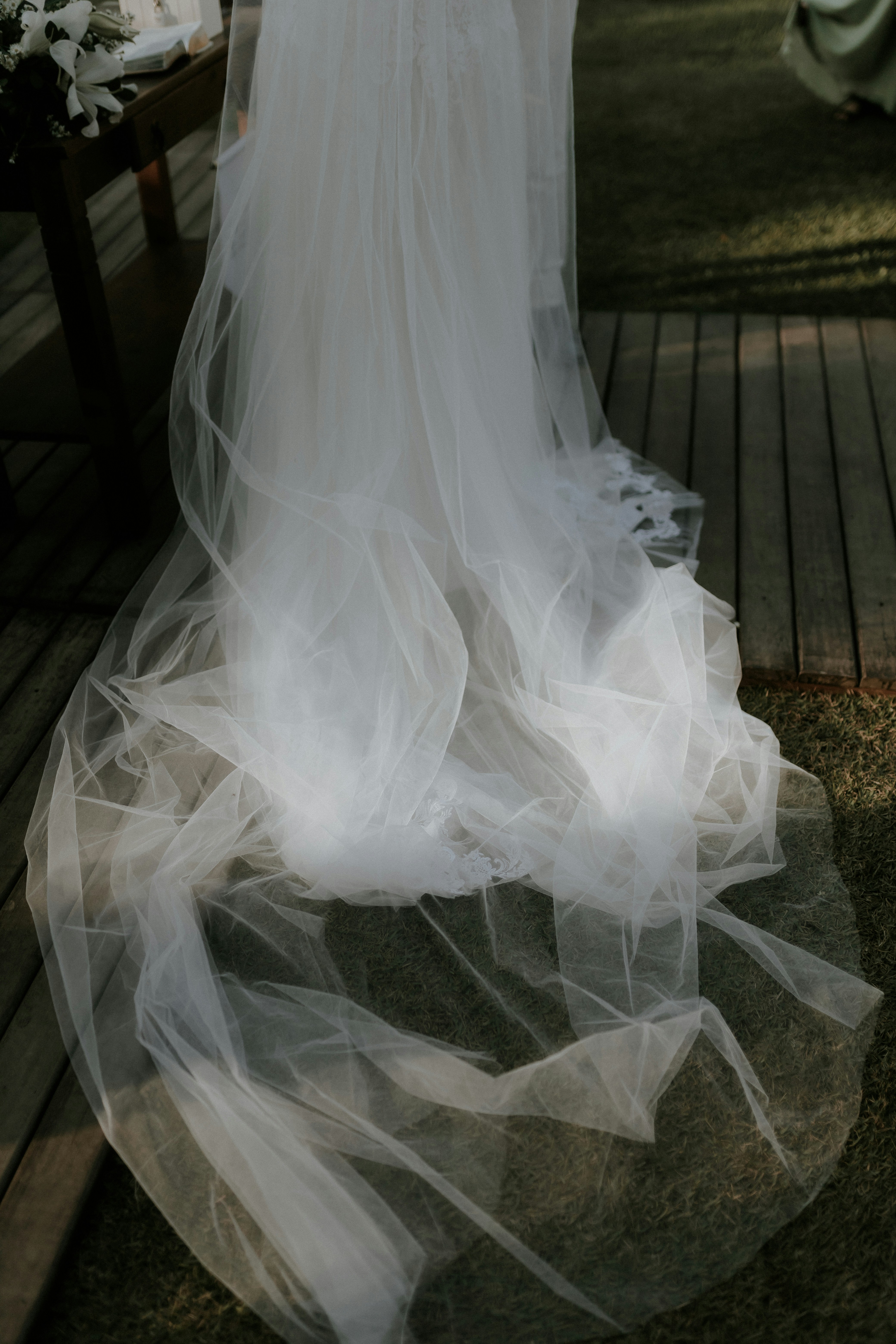 Lace and Light: The Quiet Cascade of a Bridal Train on a Wooden Deck