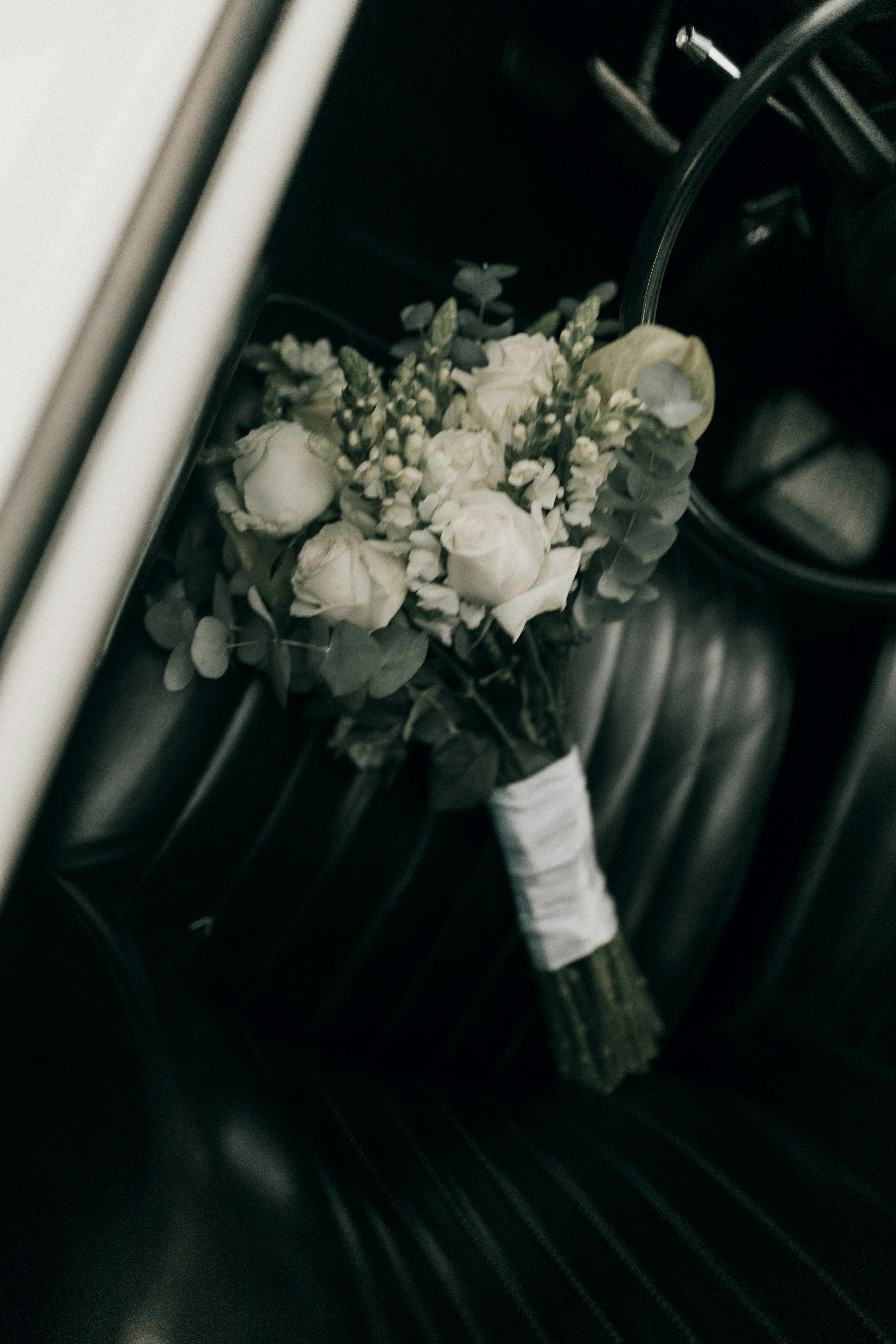 A wedding bouquet rests inside a car.