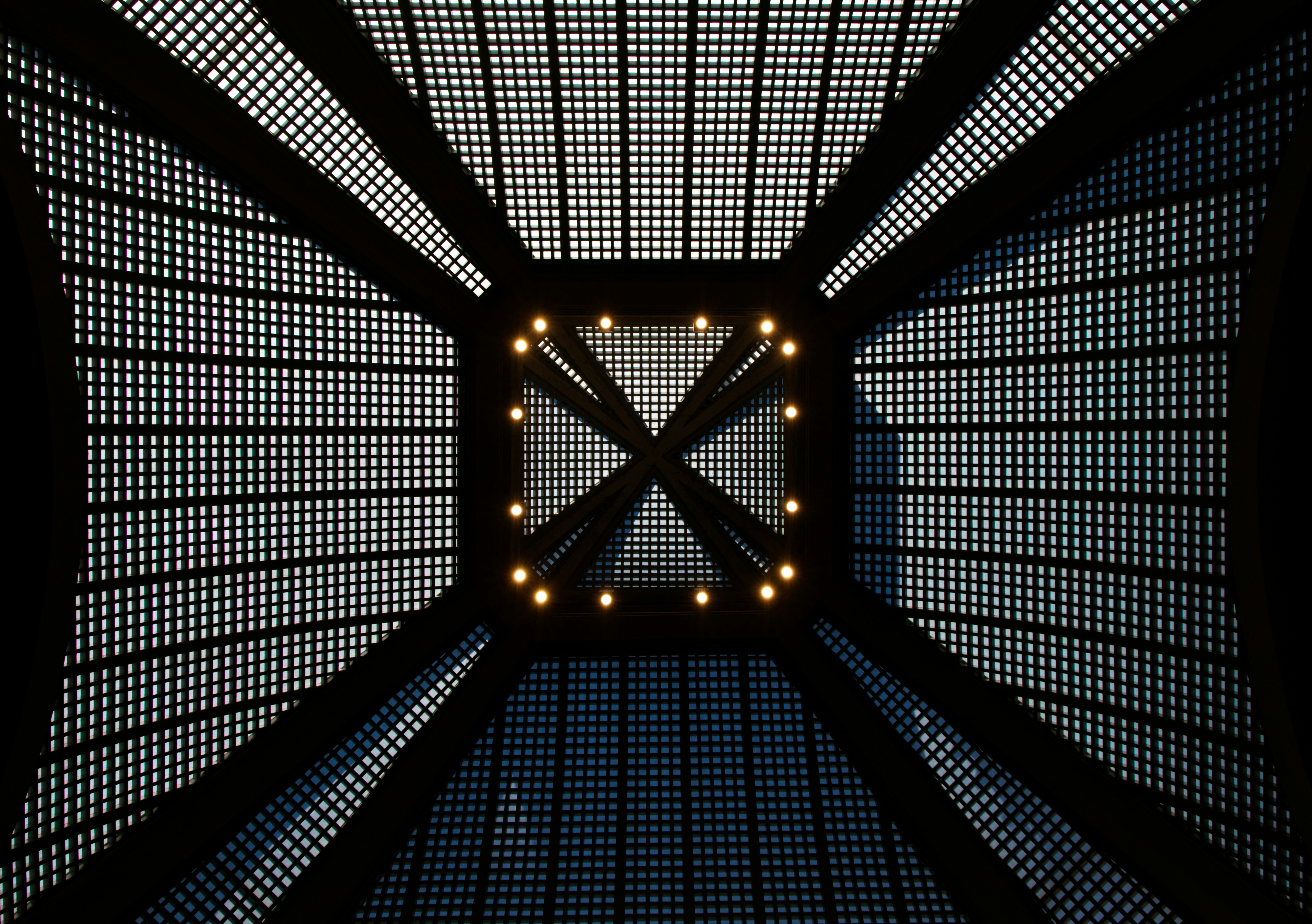 A grid ceiling with lights viewed from below.