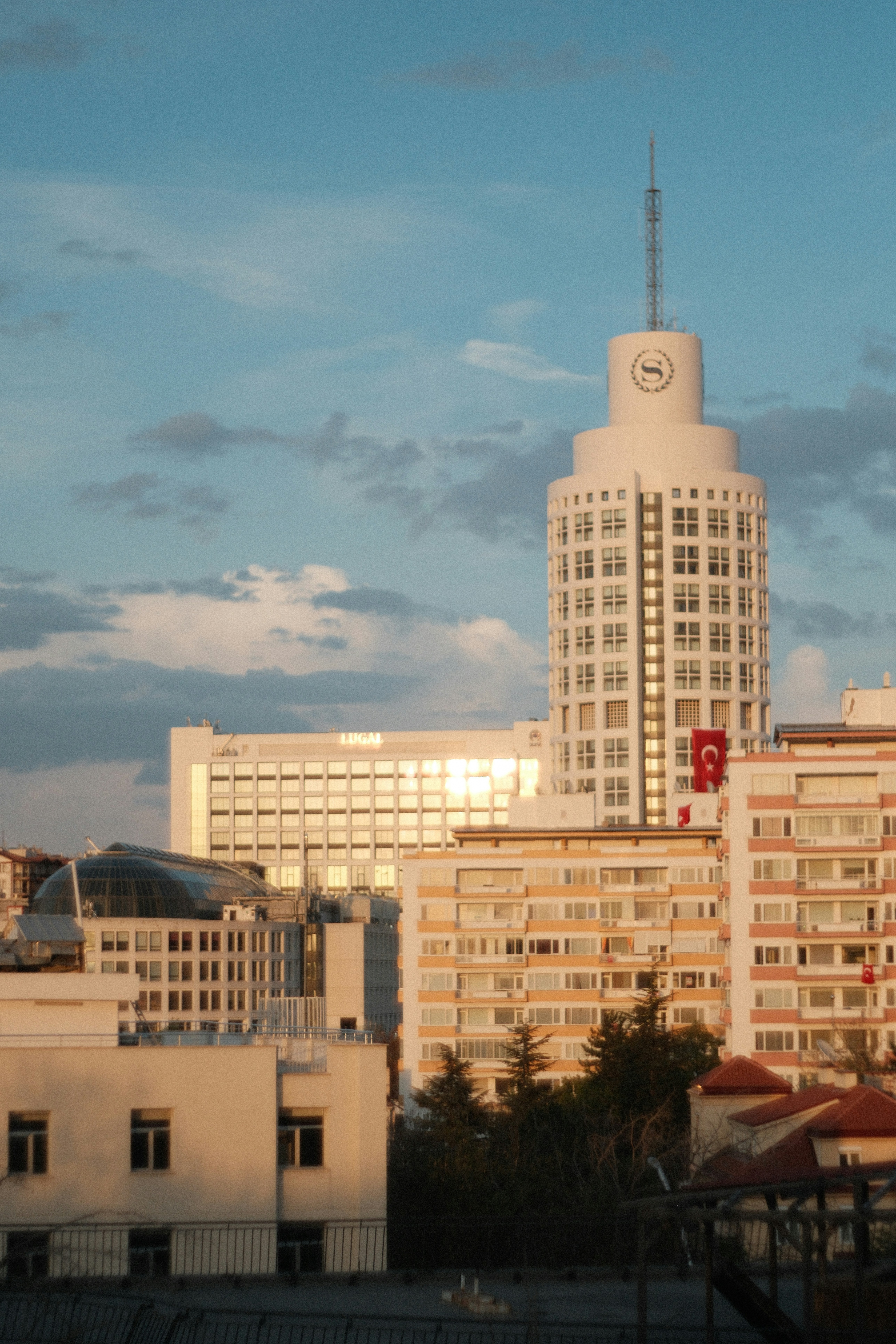 Sunlit Skyline: The Tower with a Turkish Flag Glistens at Dusk