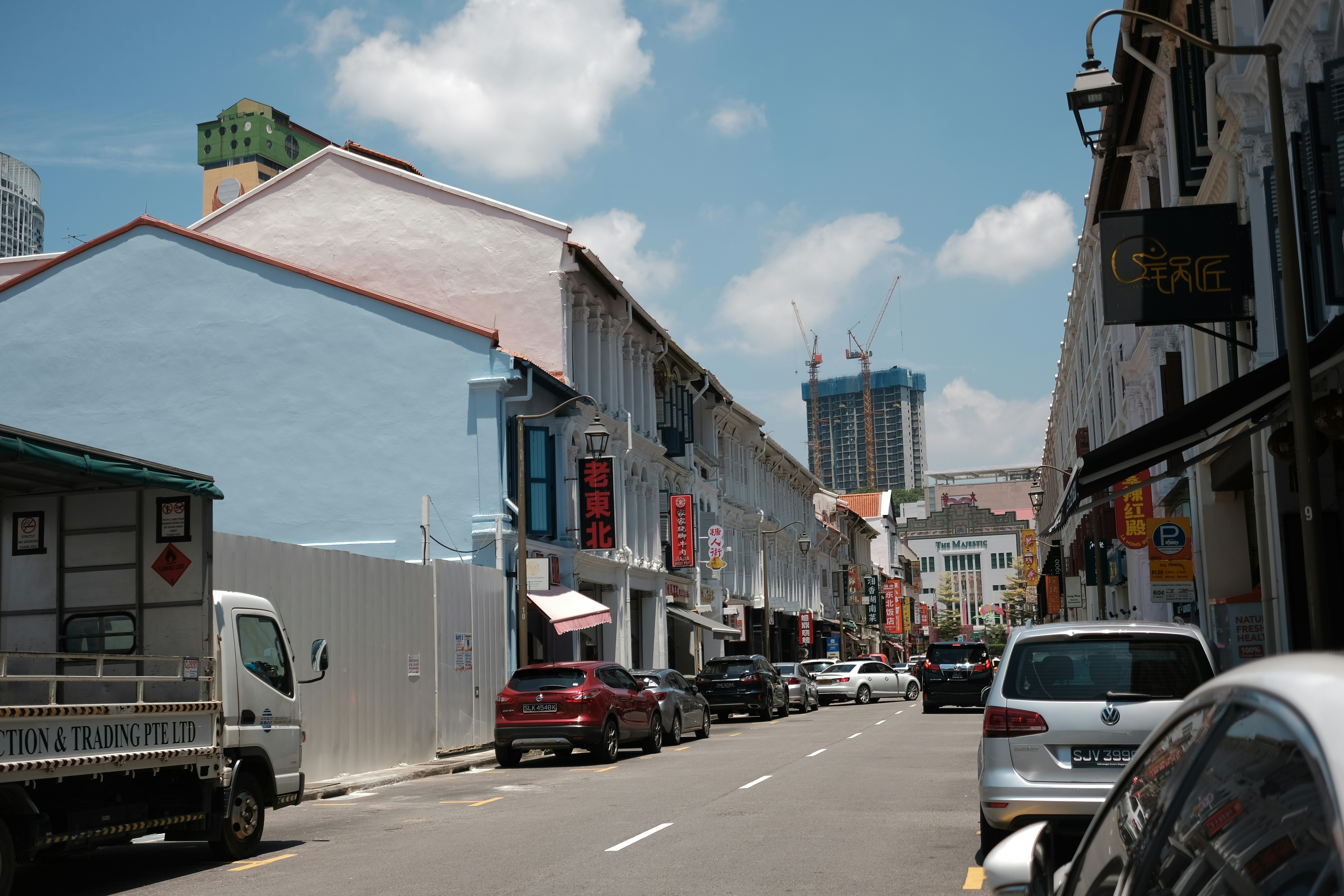 Converging Street: Sunlit Shops and a Distant Crane