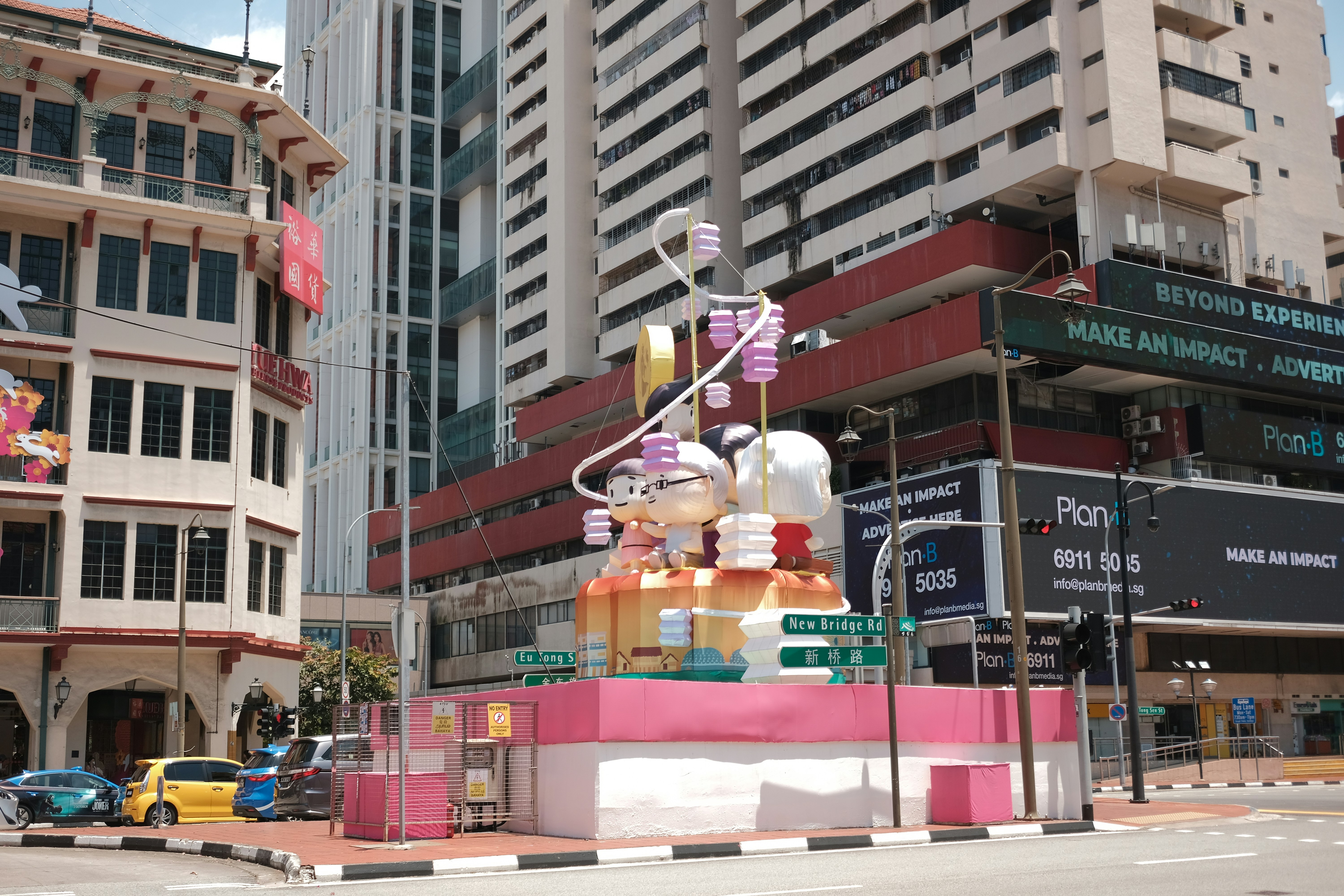 Colorful sculpture amid urban skyline and storefronts