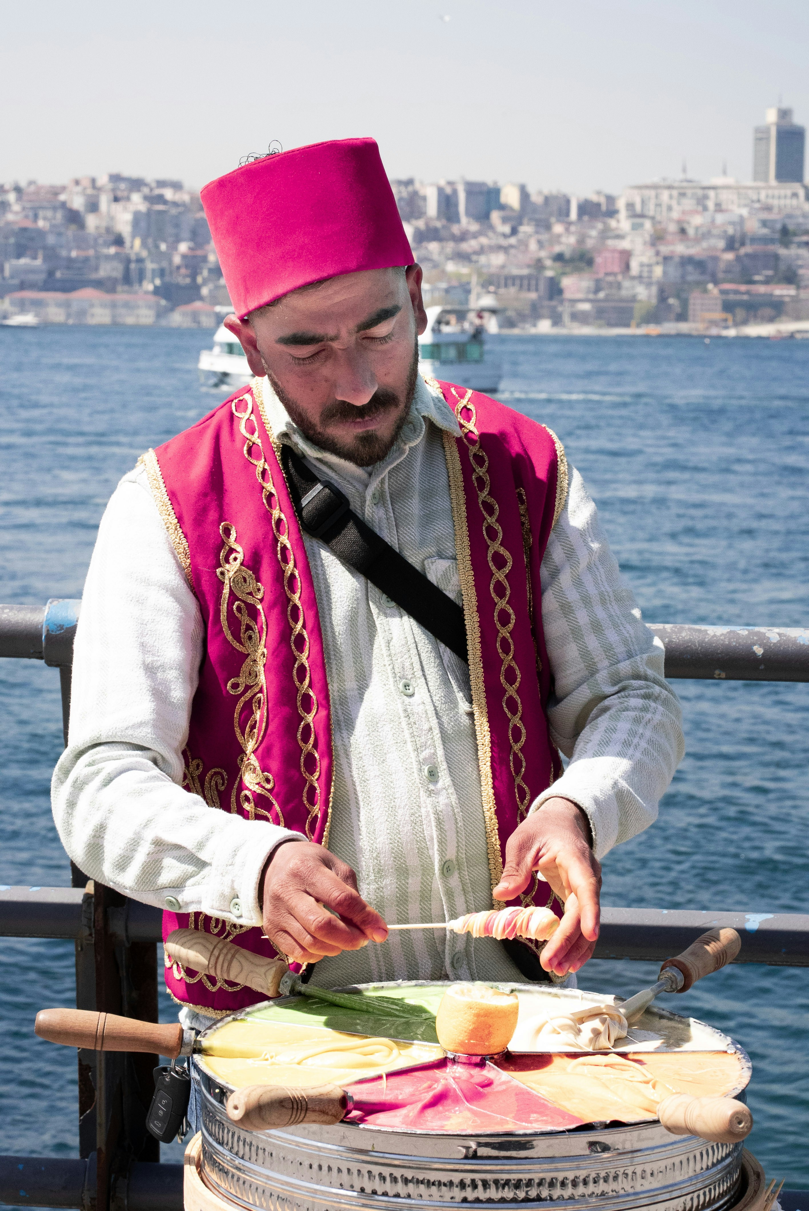 Harbor Rhythm in Magenta: A Pink-Vested Drummer by the Sea