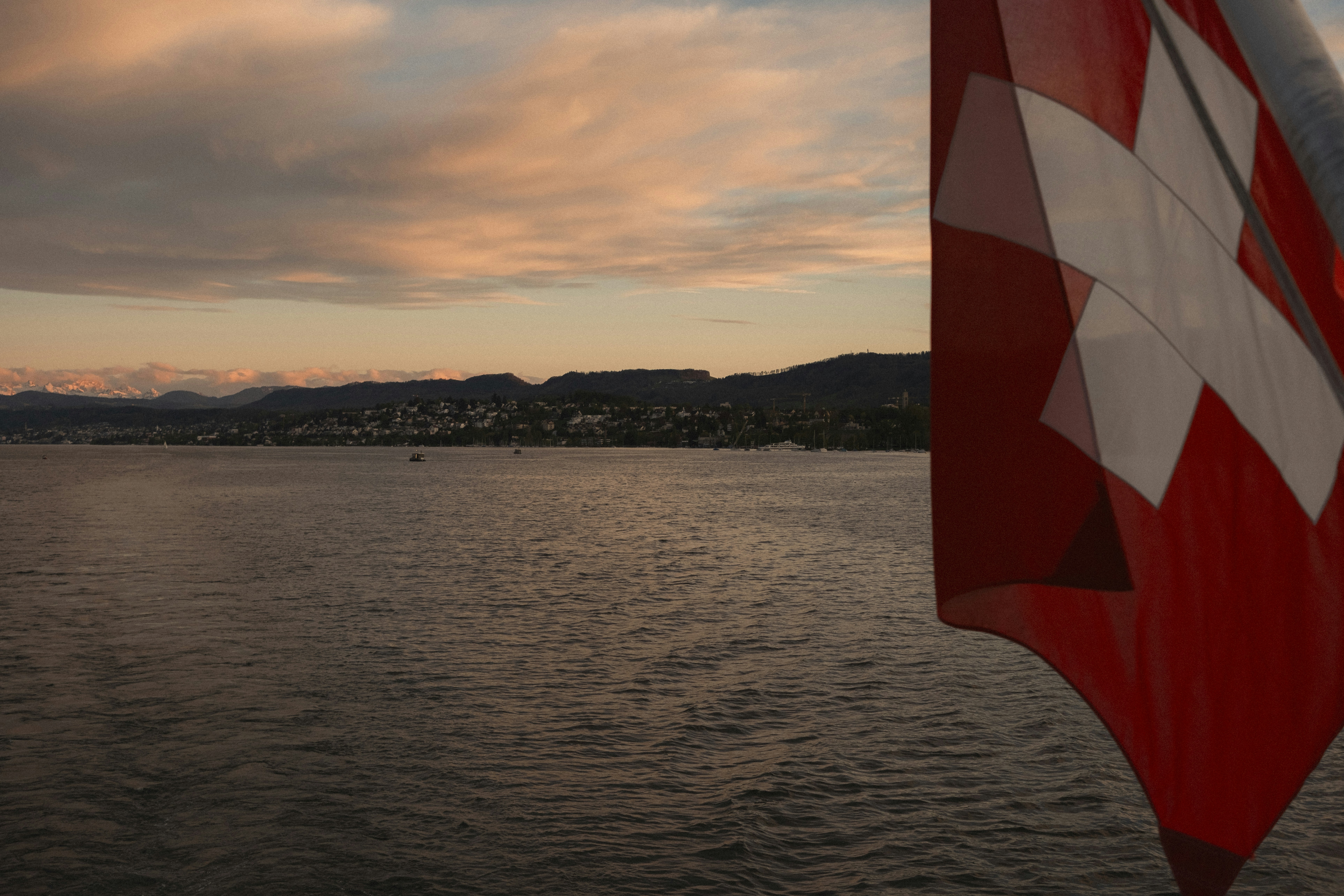 Swiss Flag Framing a Quiet Lake Sunset