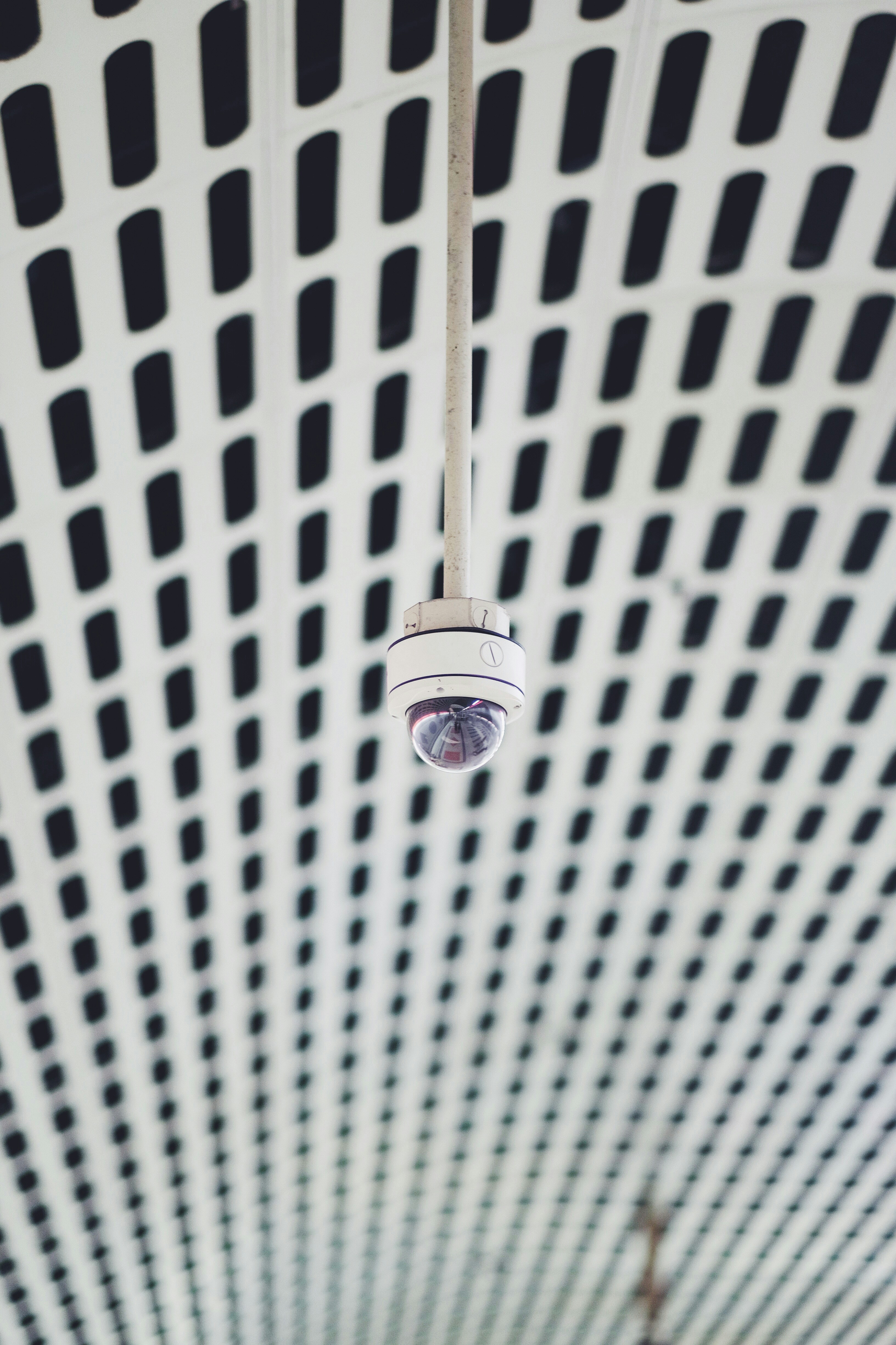 A security camera hangs from a patterned ceiling. photo – Free White ...