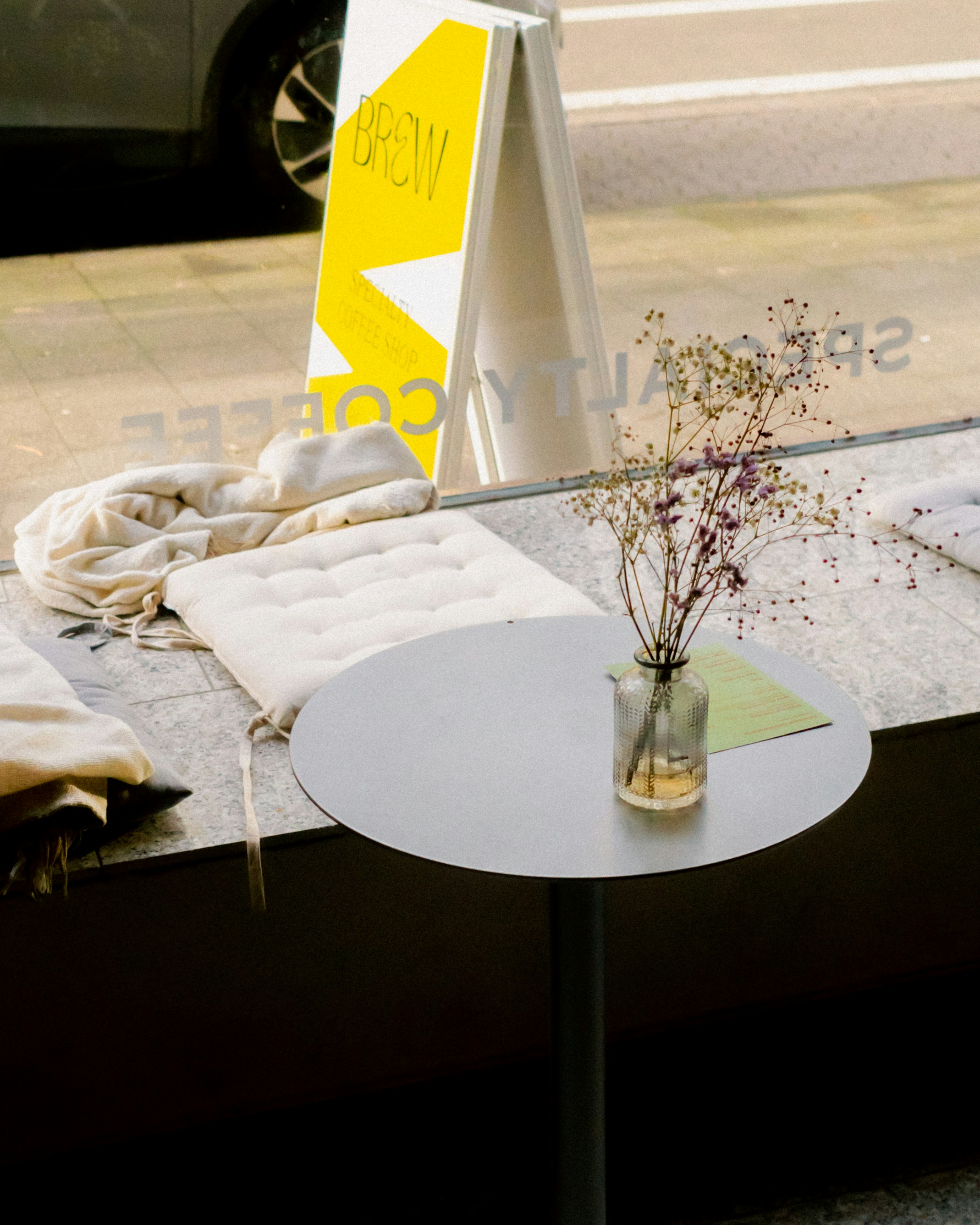 A table is set up in a coffee shop window. photo – Free Cafe Image on ...