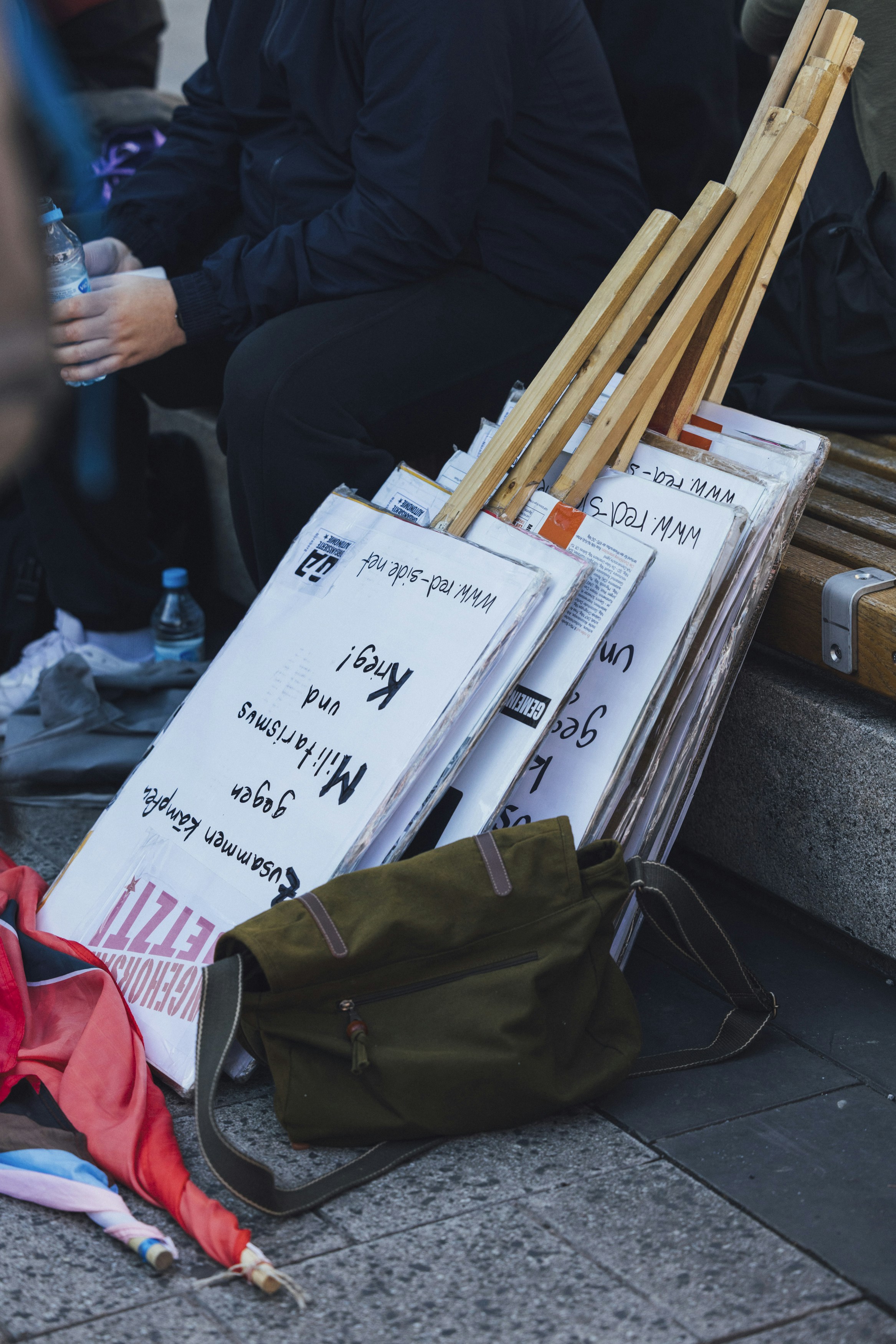 Signs and a bag rest near a person's legs. photo – Free Donald trump ...