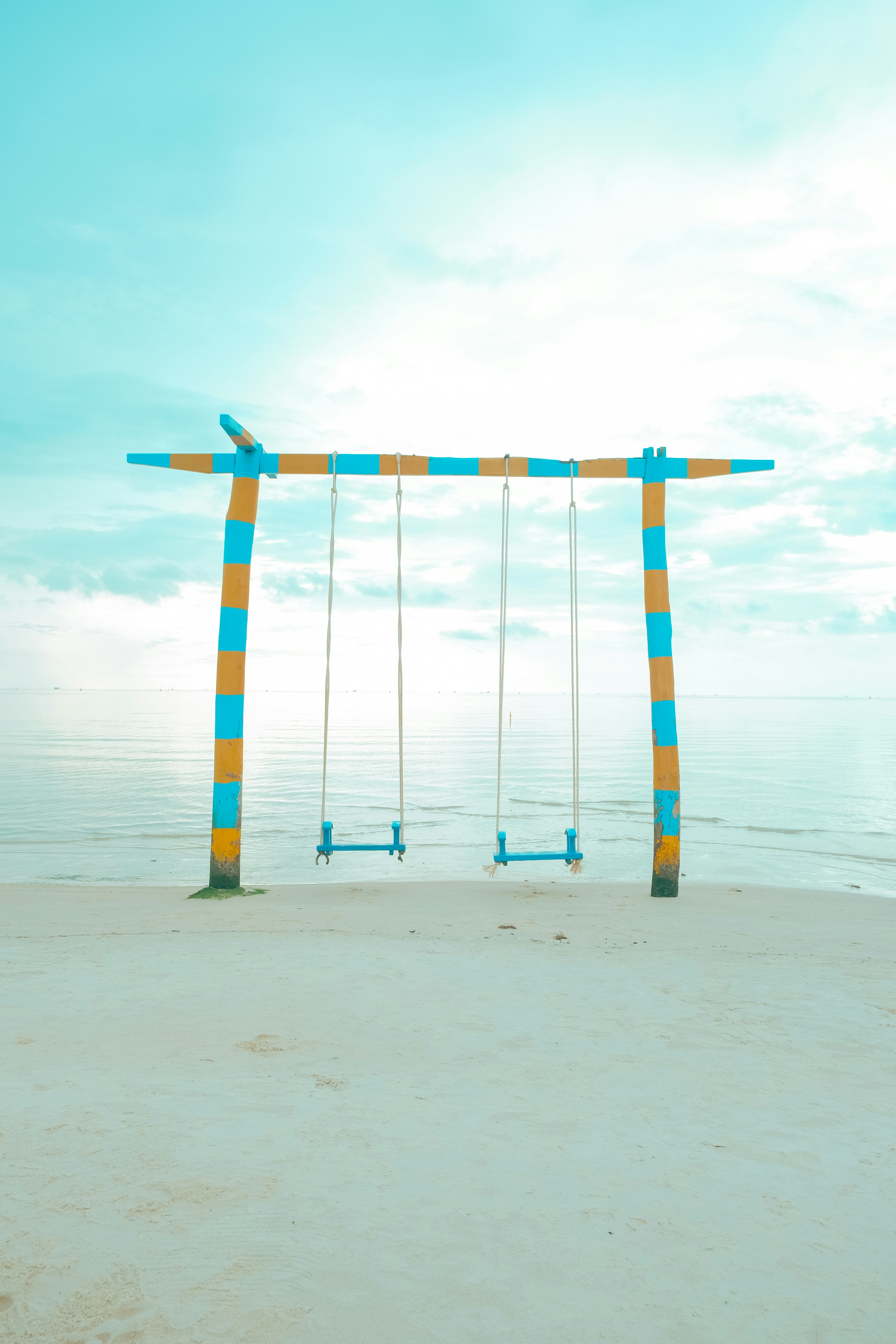 Candy-Striped Swing Framing a Quiet Beach Horizon