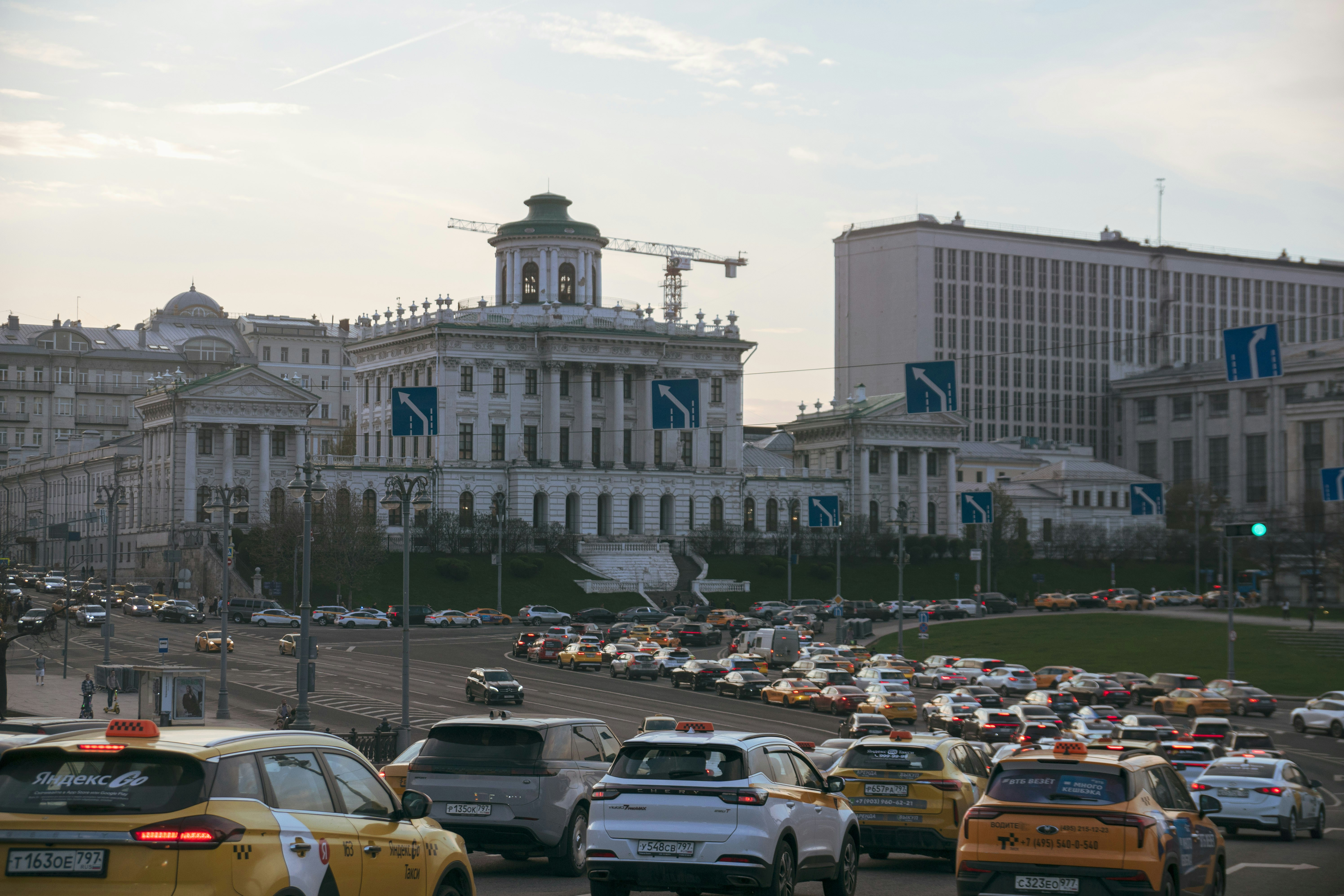 Cars driving past a large classical building. photo – Free Building ...