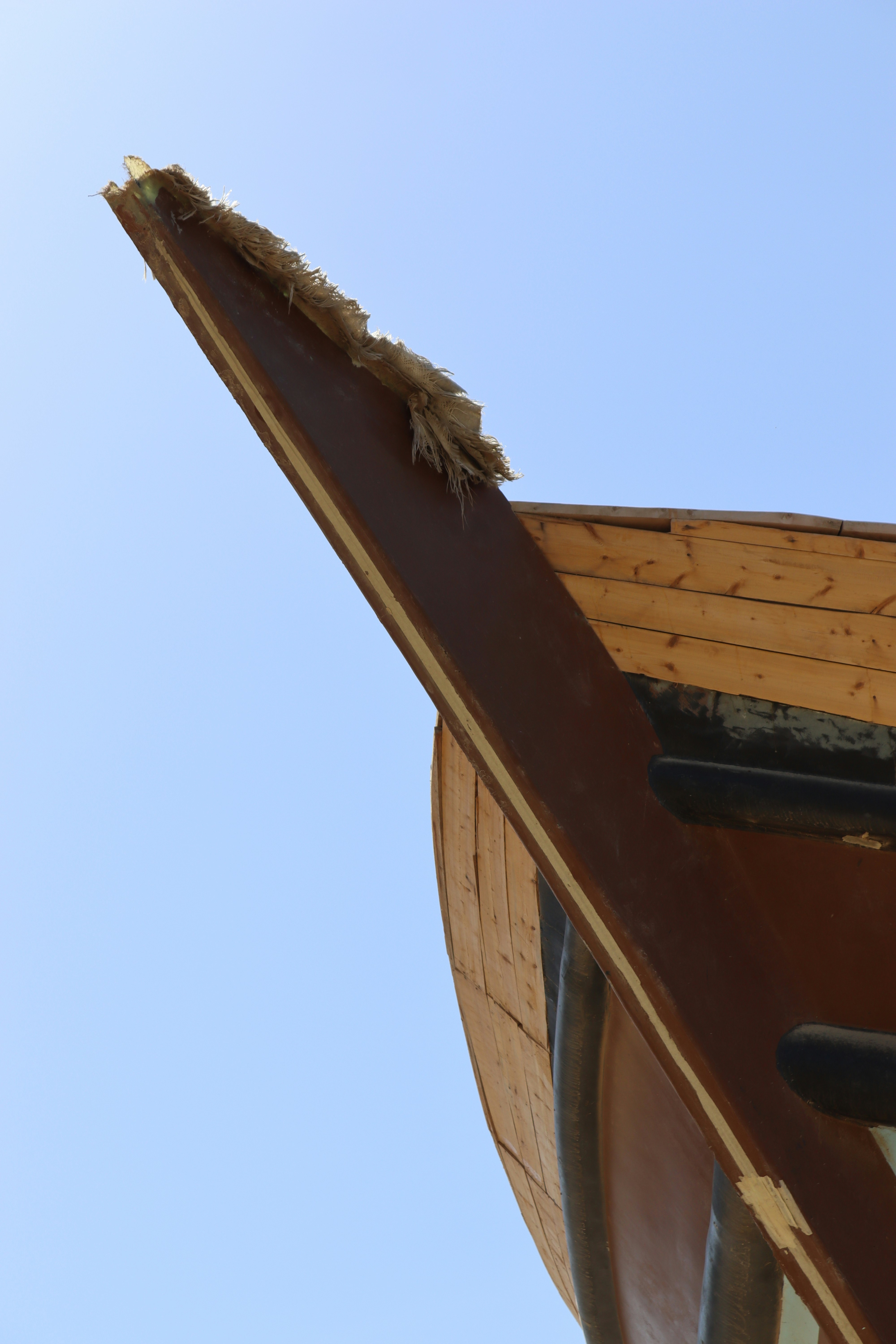 Edge of a Rooftop: Frayed Timber Against a Clear Sky