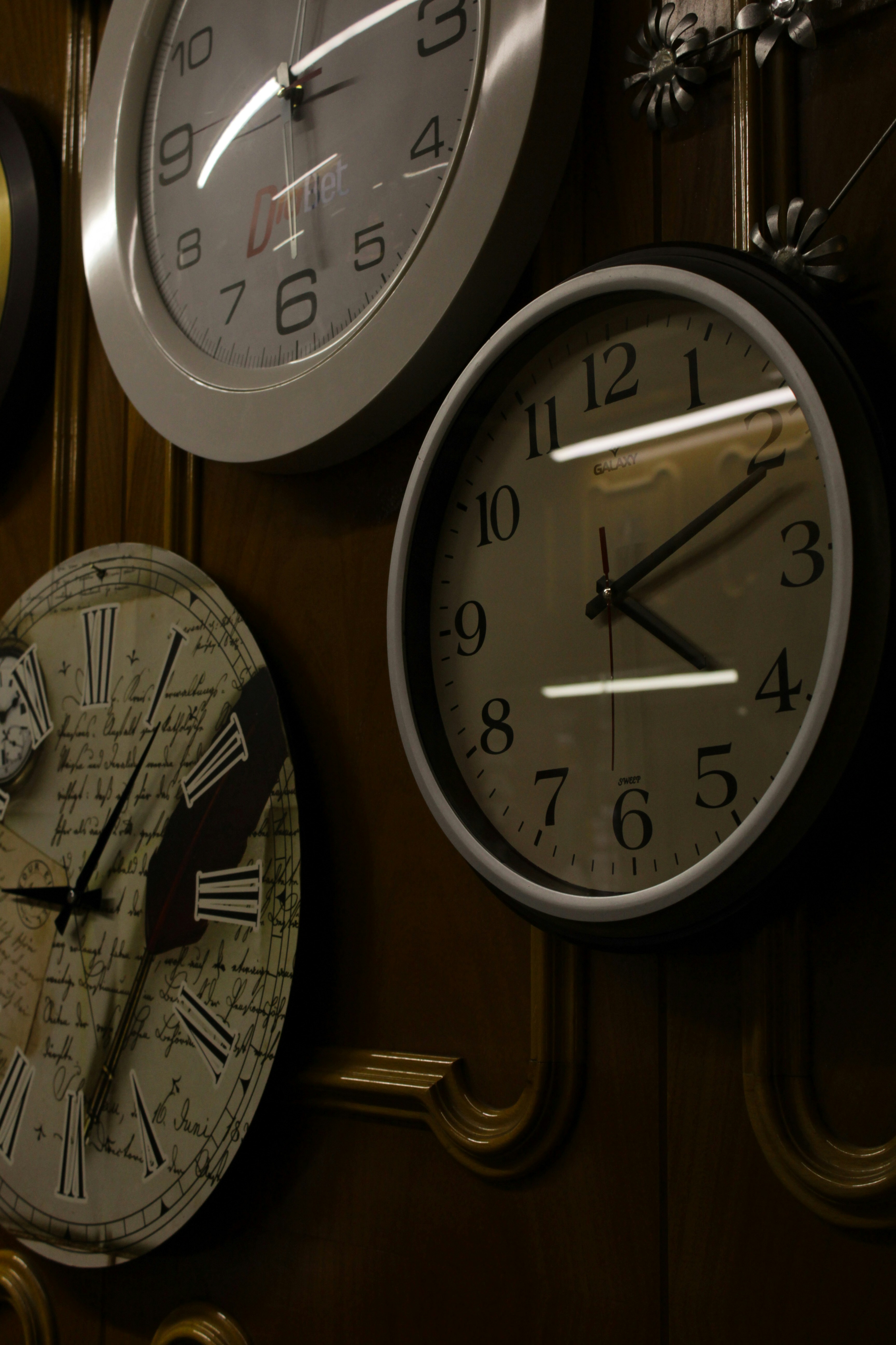Several clocks are hanging on a wall. photo – Free Dark Image on Unsplash