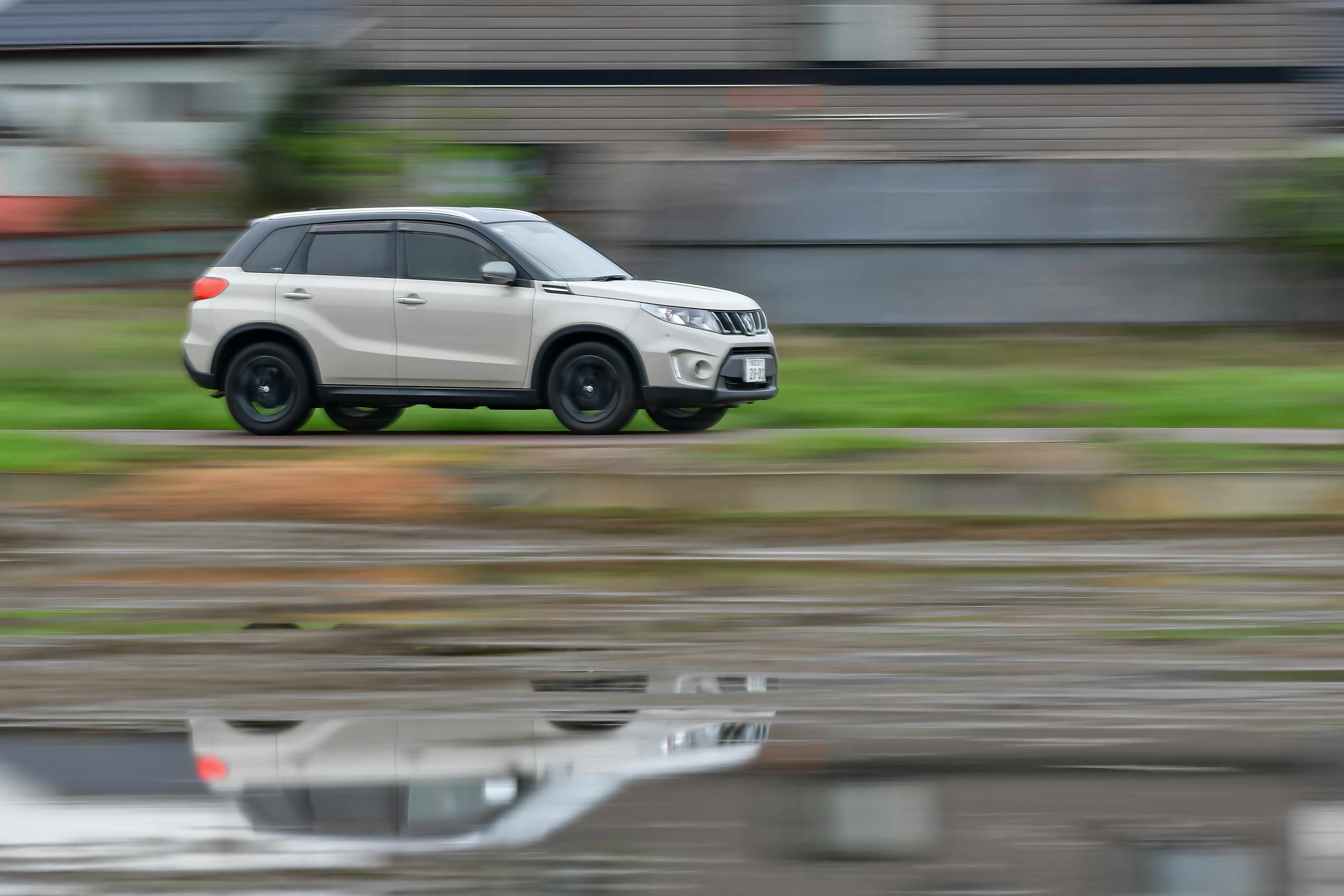 Panning Glide: White SUV Slices Through Industrial Blur and Reflections