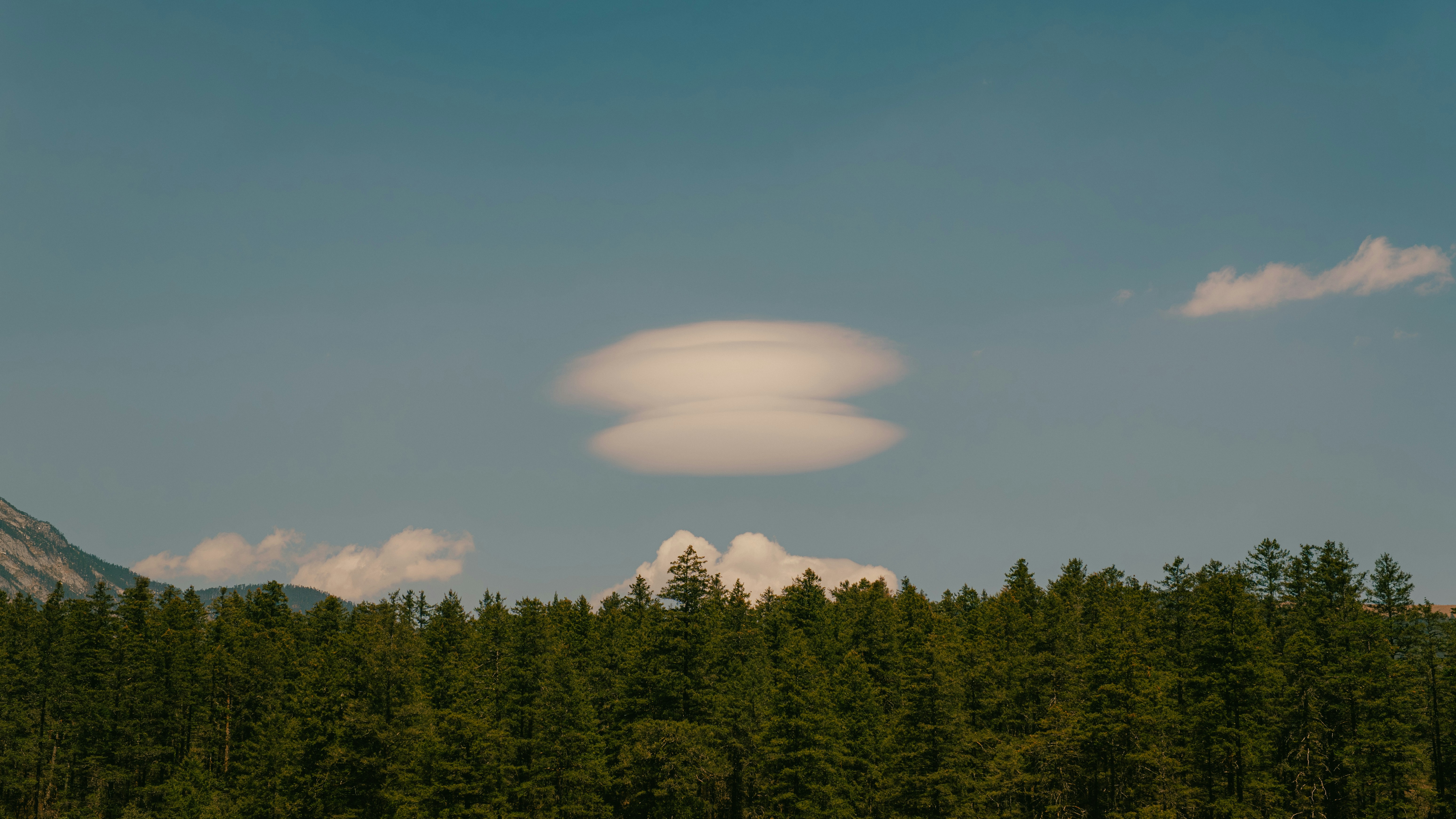 Levitation over the Pines: A Surreal Sky Cloud Ring Over a Mountain Crest