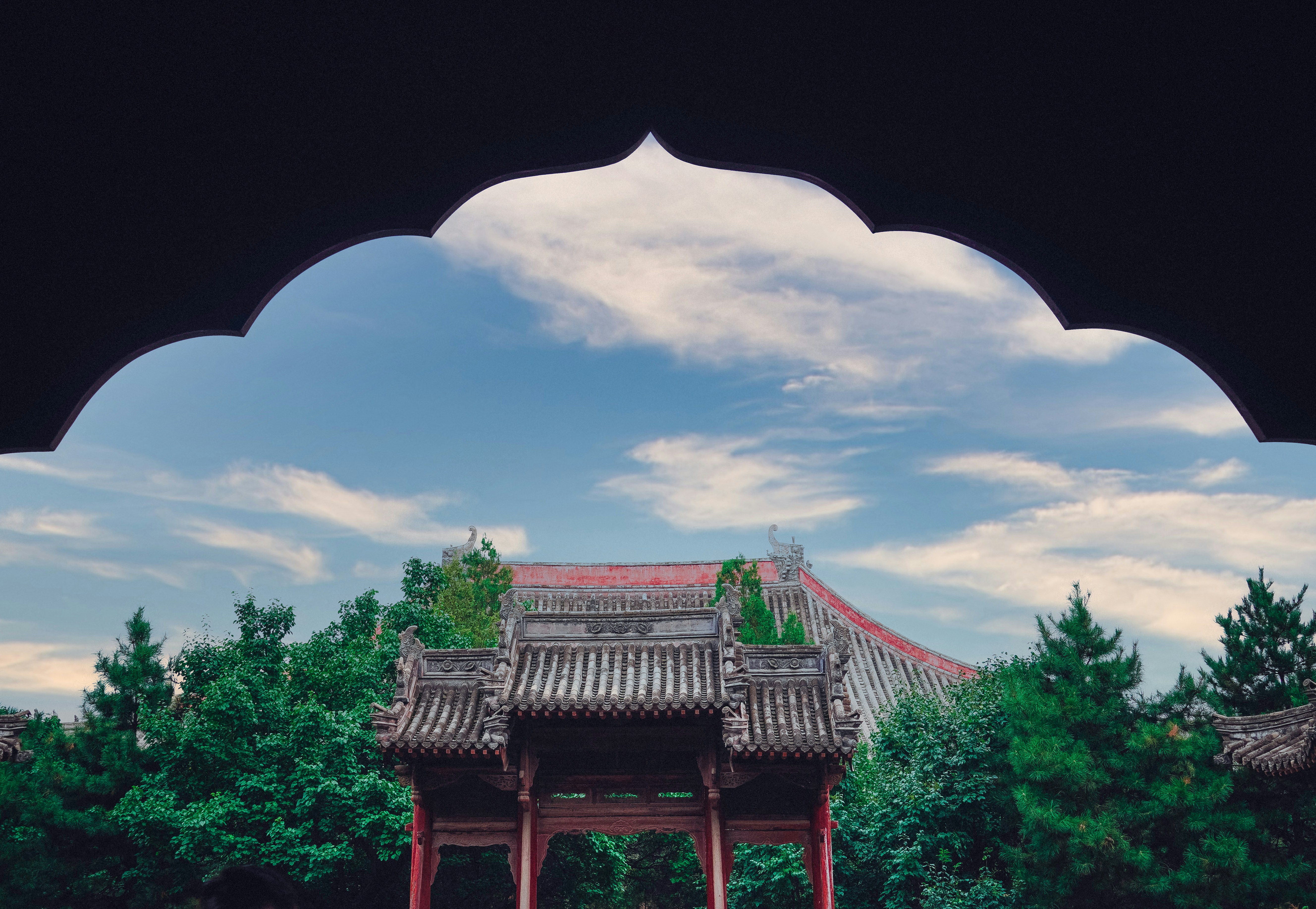 Temple Gate Silhouette: Hidden Sky Over Courtyard Rooflines