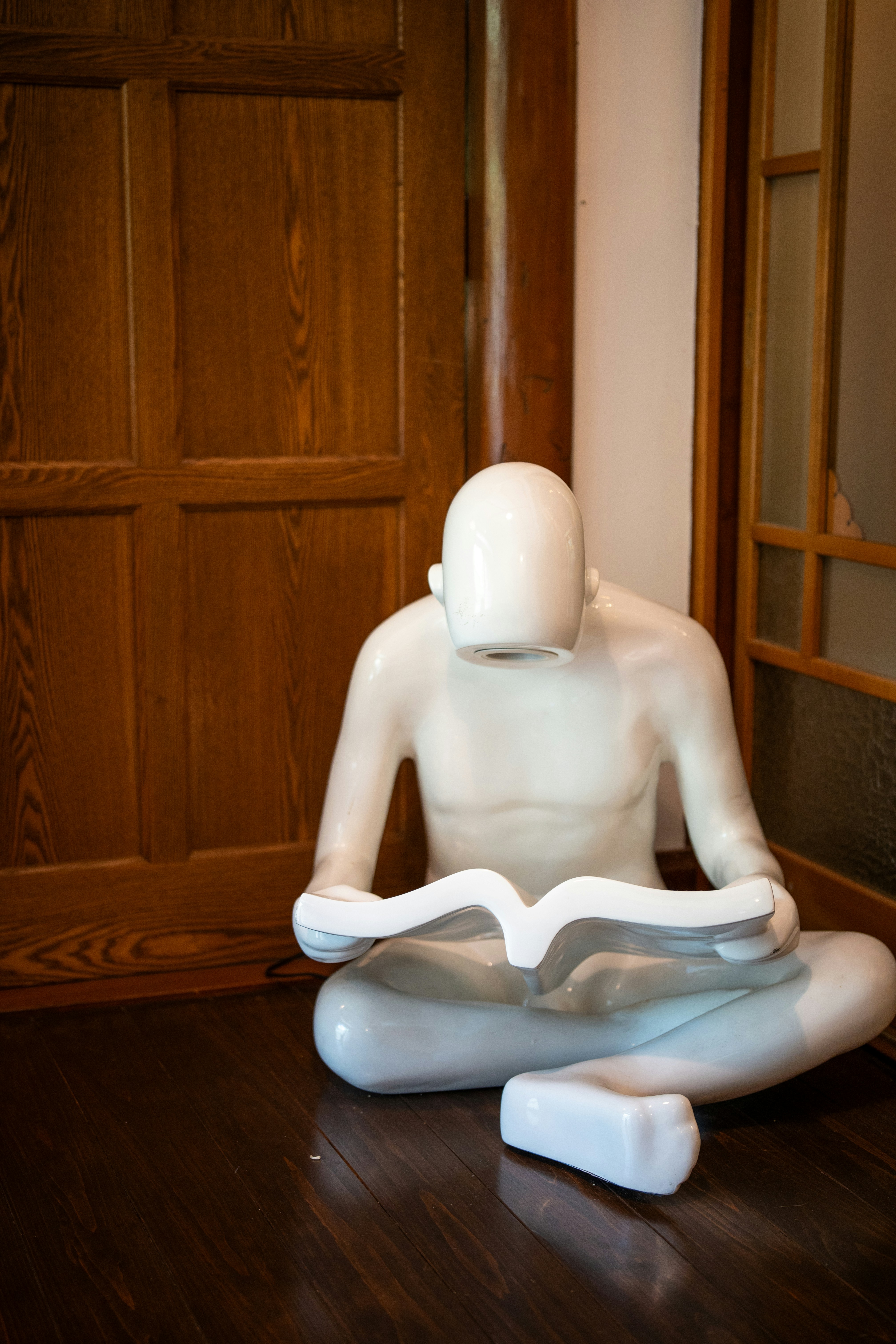 Silent Figure Reading: A White Pod Pose in a Quiet Corner