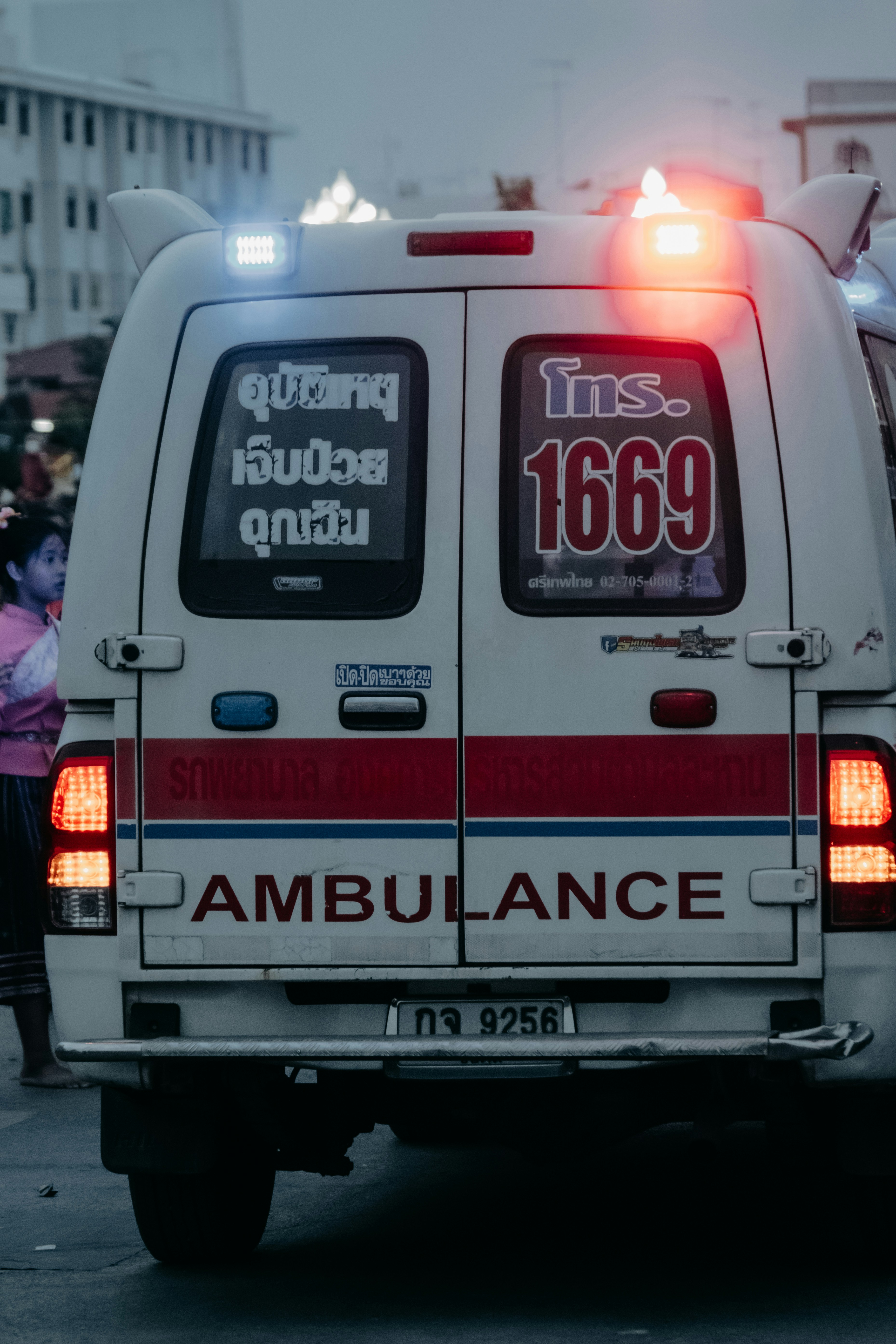 Crimson and Azure Beacons: The Back of a City Ambulance at Dusk