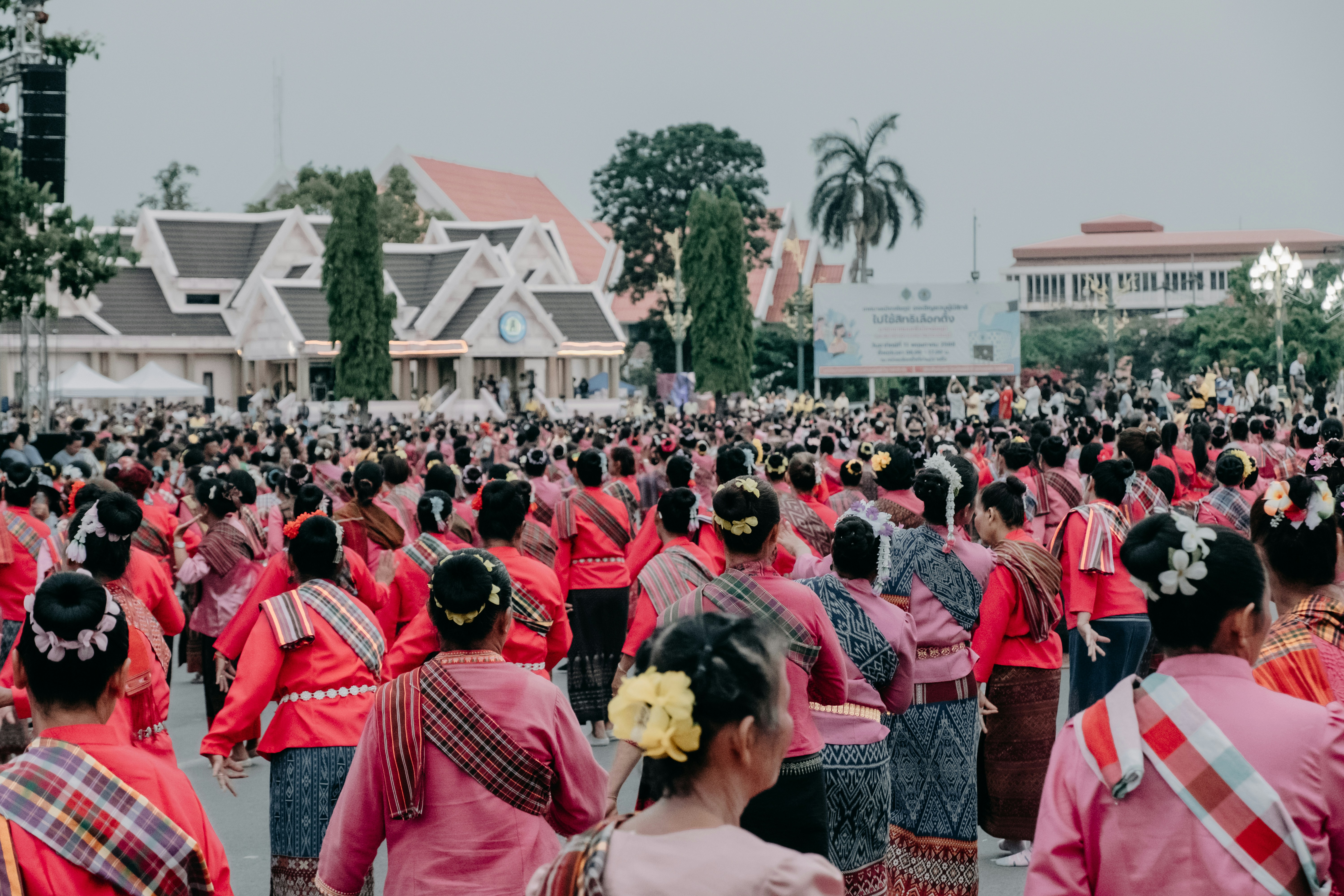 People in pink outfits dance in a crowded plaza. photo – Free Image on ...