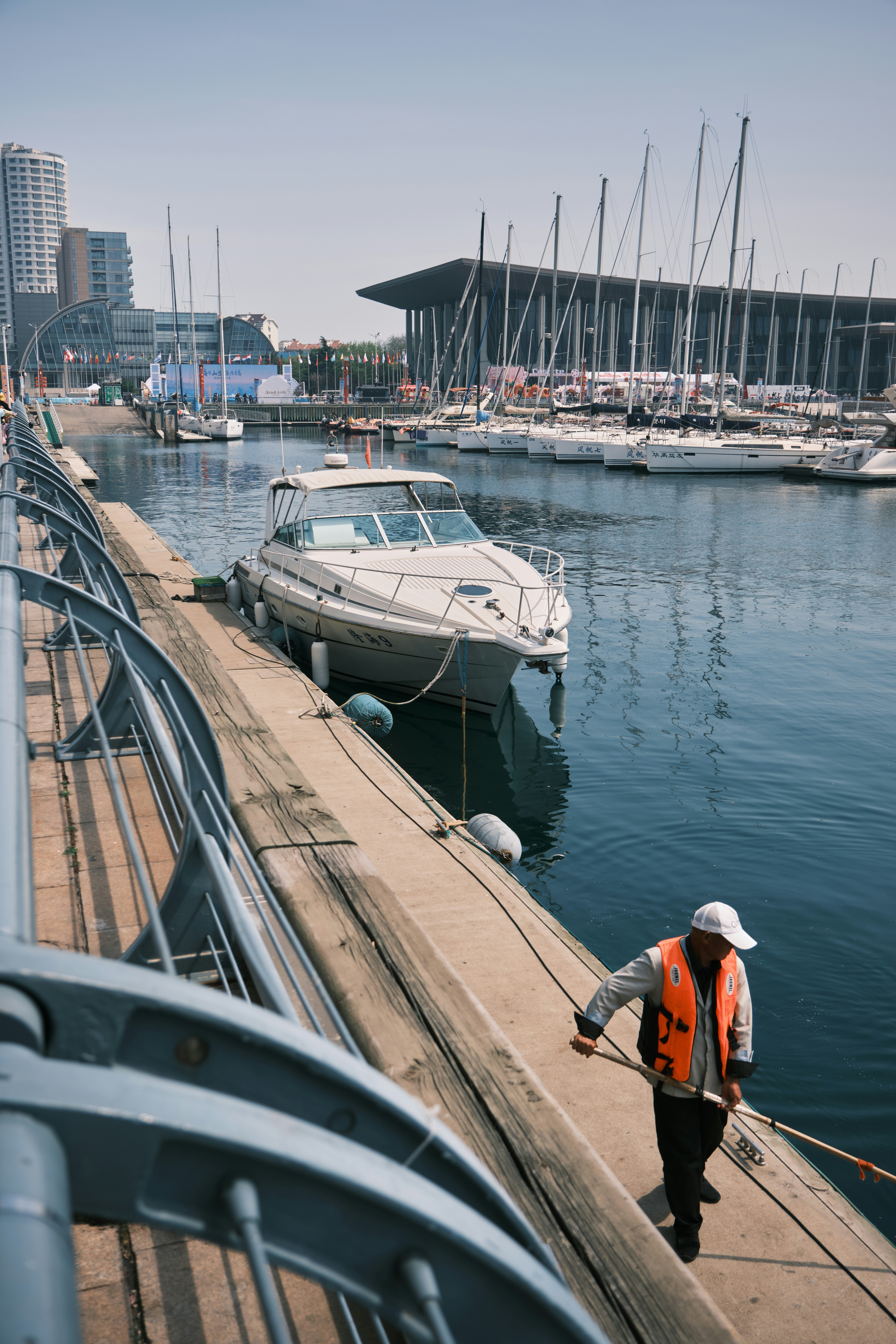 A harbor worker walks next to docked boats. photo – Free Image on Unsplash
