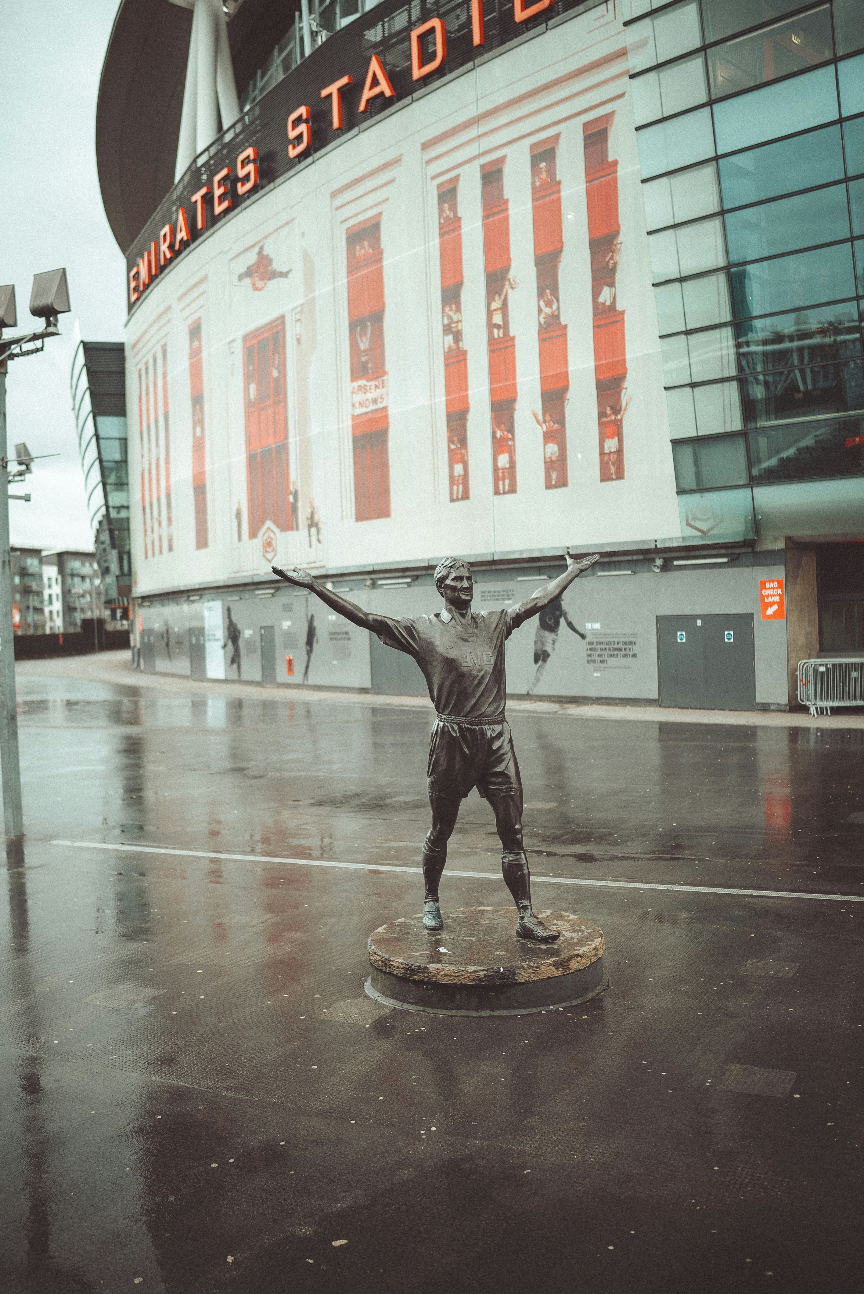 Open-Armed Bronze Guardian: Rainy Silence Outside Emirates Stadium