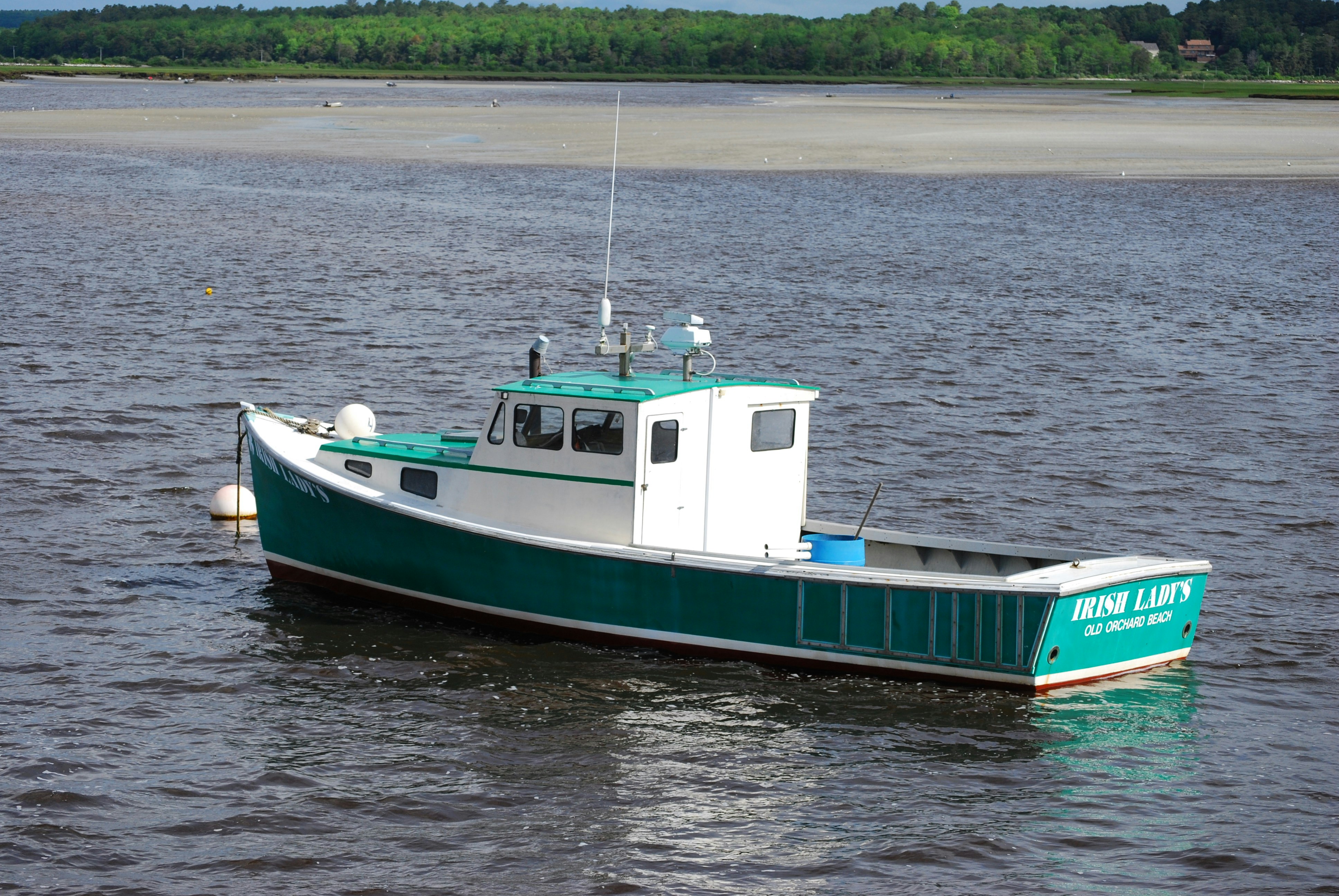 A teal fishing boat floats on water. photo – Free Usa Image on Unsplash