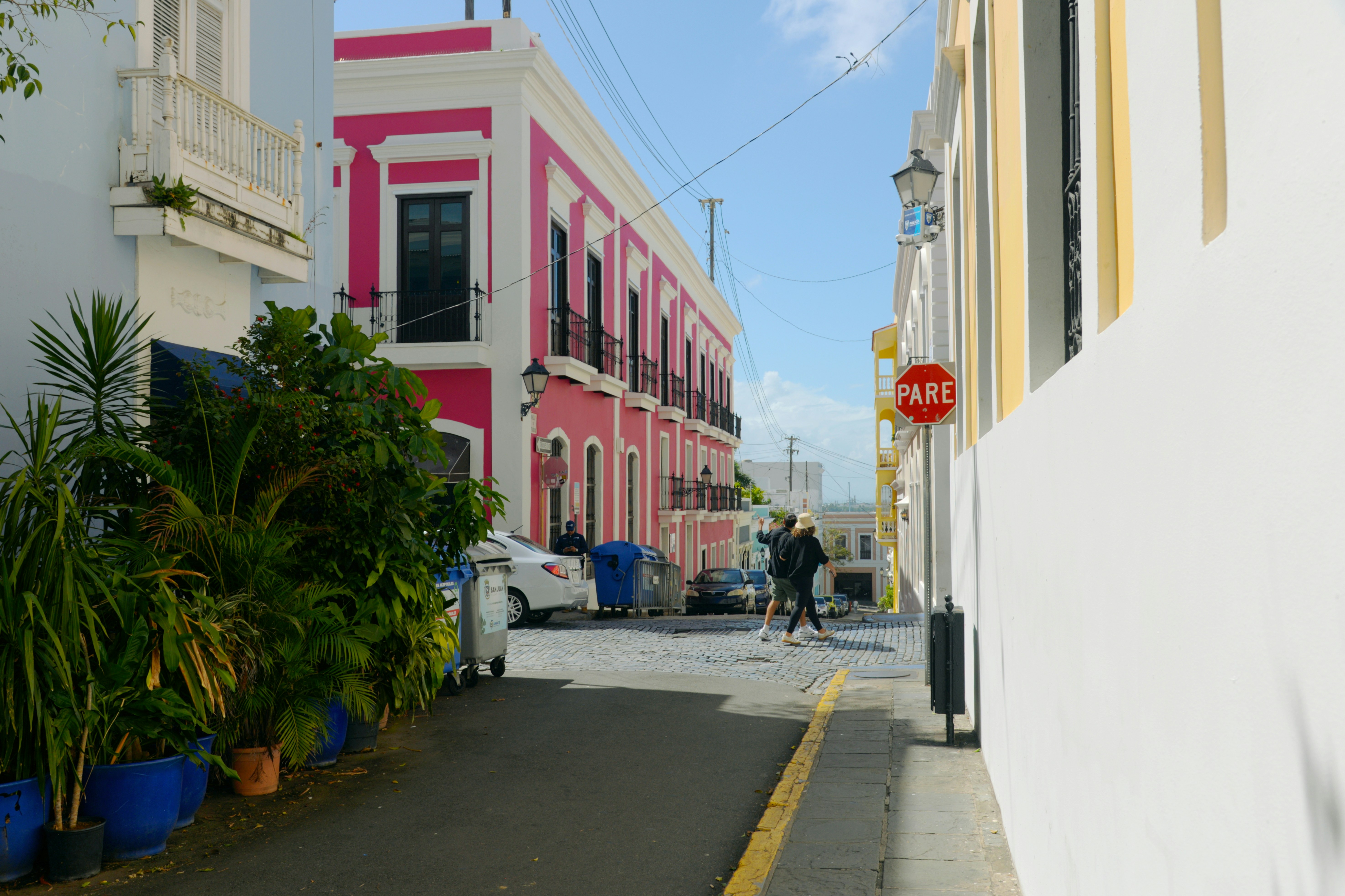 Pastel Corridor: Sunlit Alley Between Pink Facades
